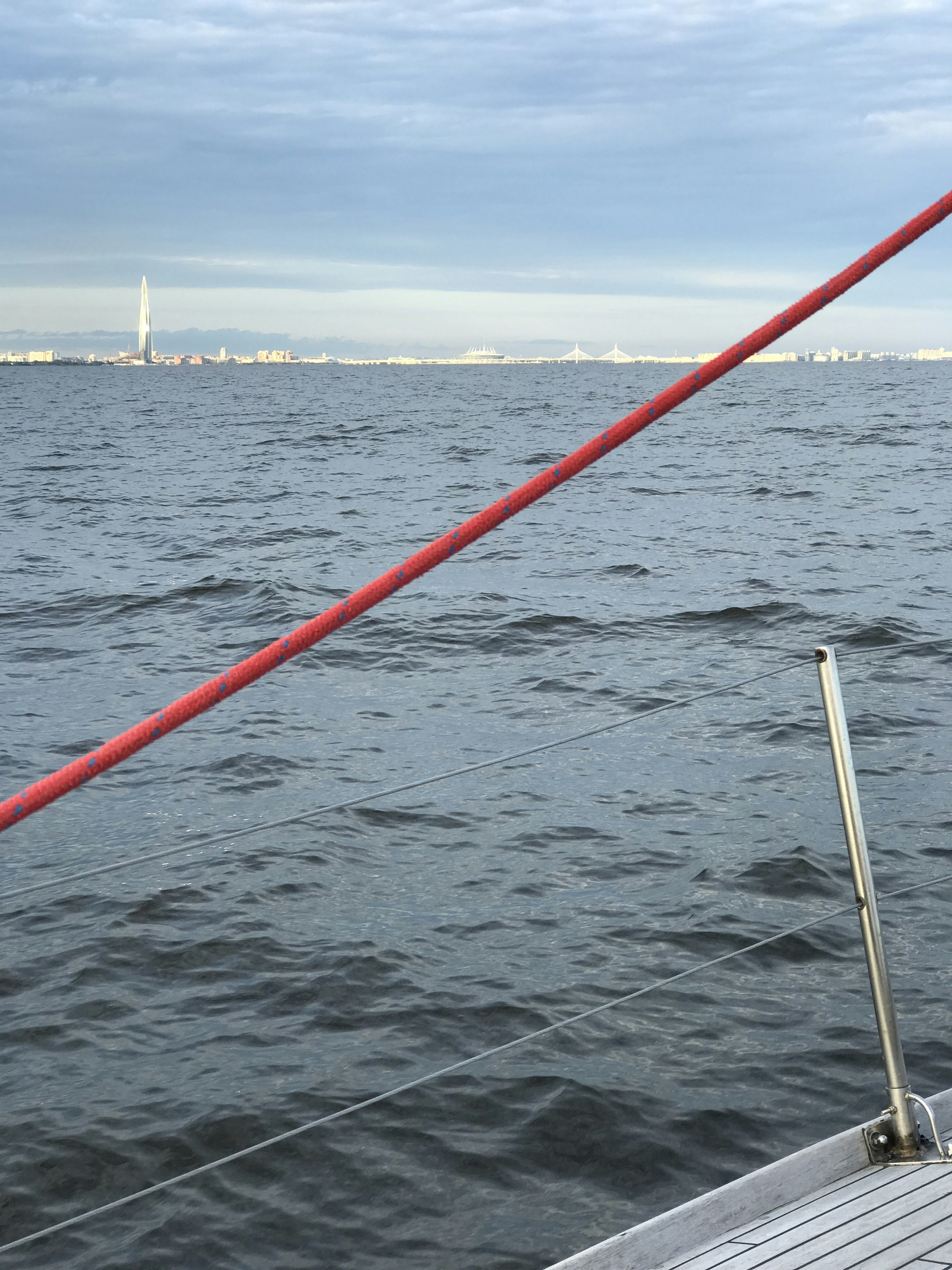 Red Rail Across the Sea: A Sailboat View with Horizon Lines