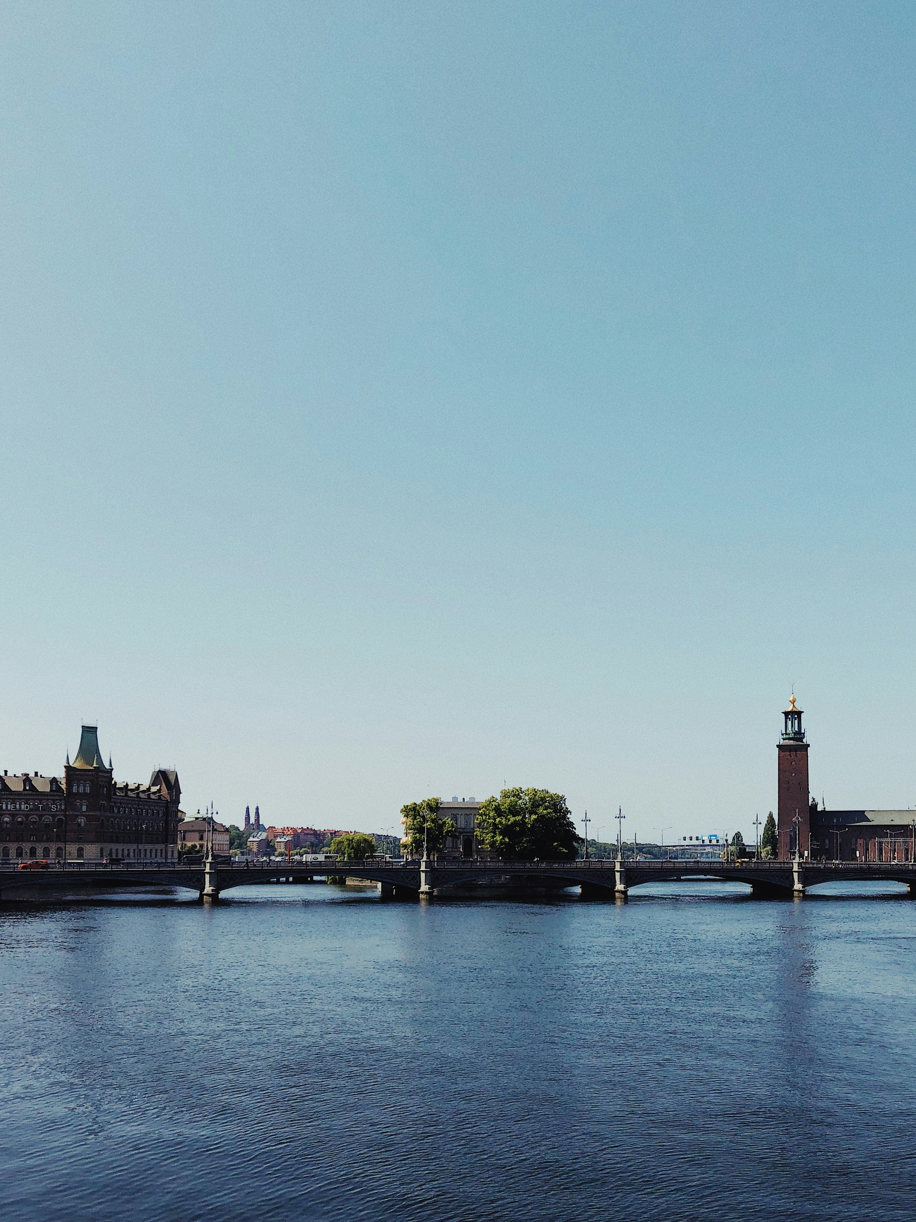 Brick and Waterlines: A Quiet City Bridge Framed by Towers Under a Clear Sky