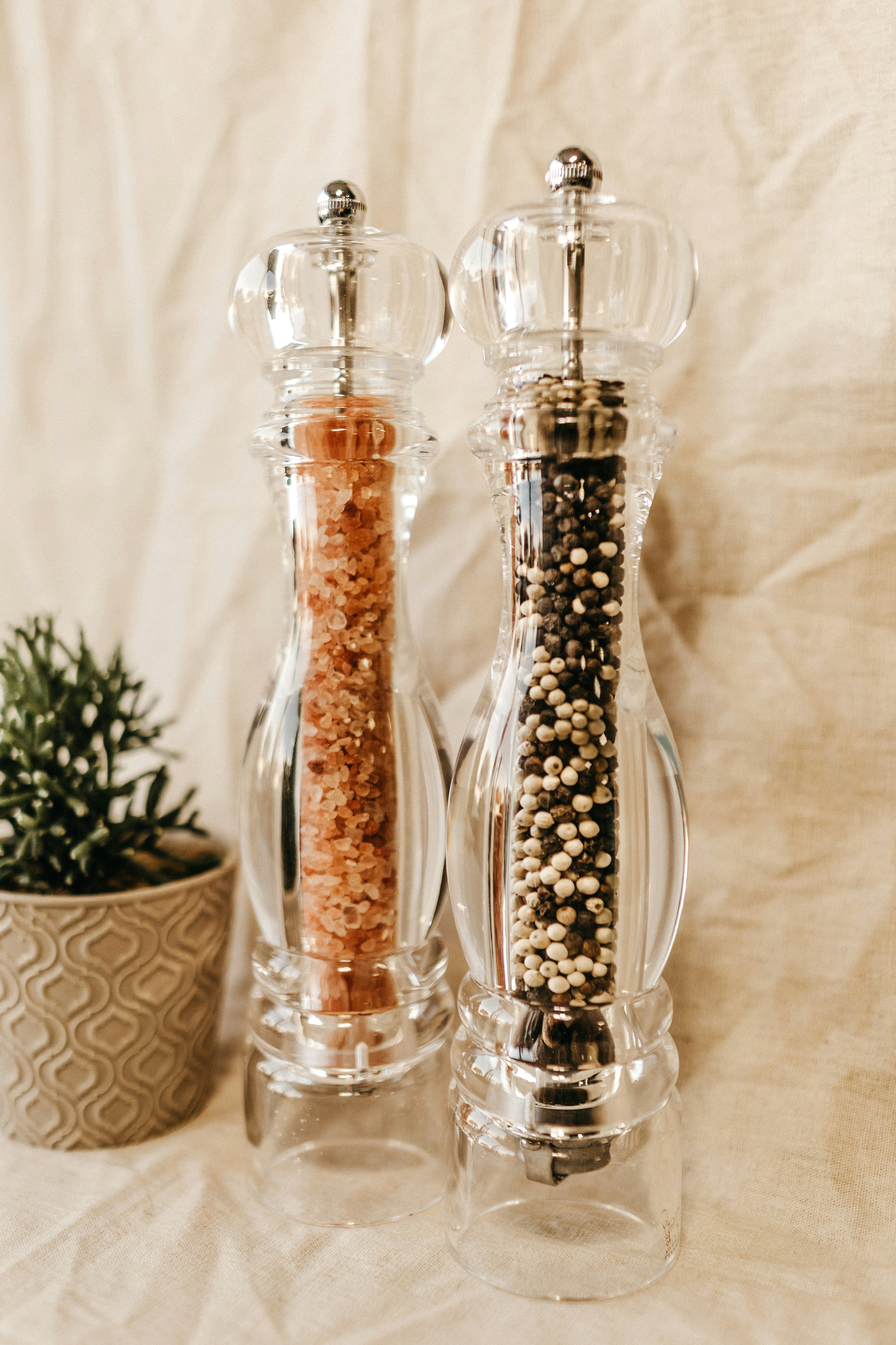Twin Glass Salt and Pepper Mills Framed by Linen