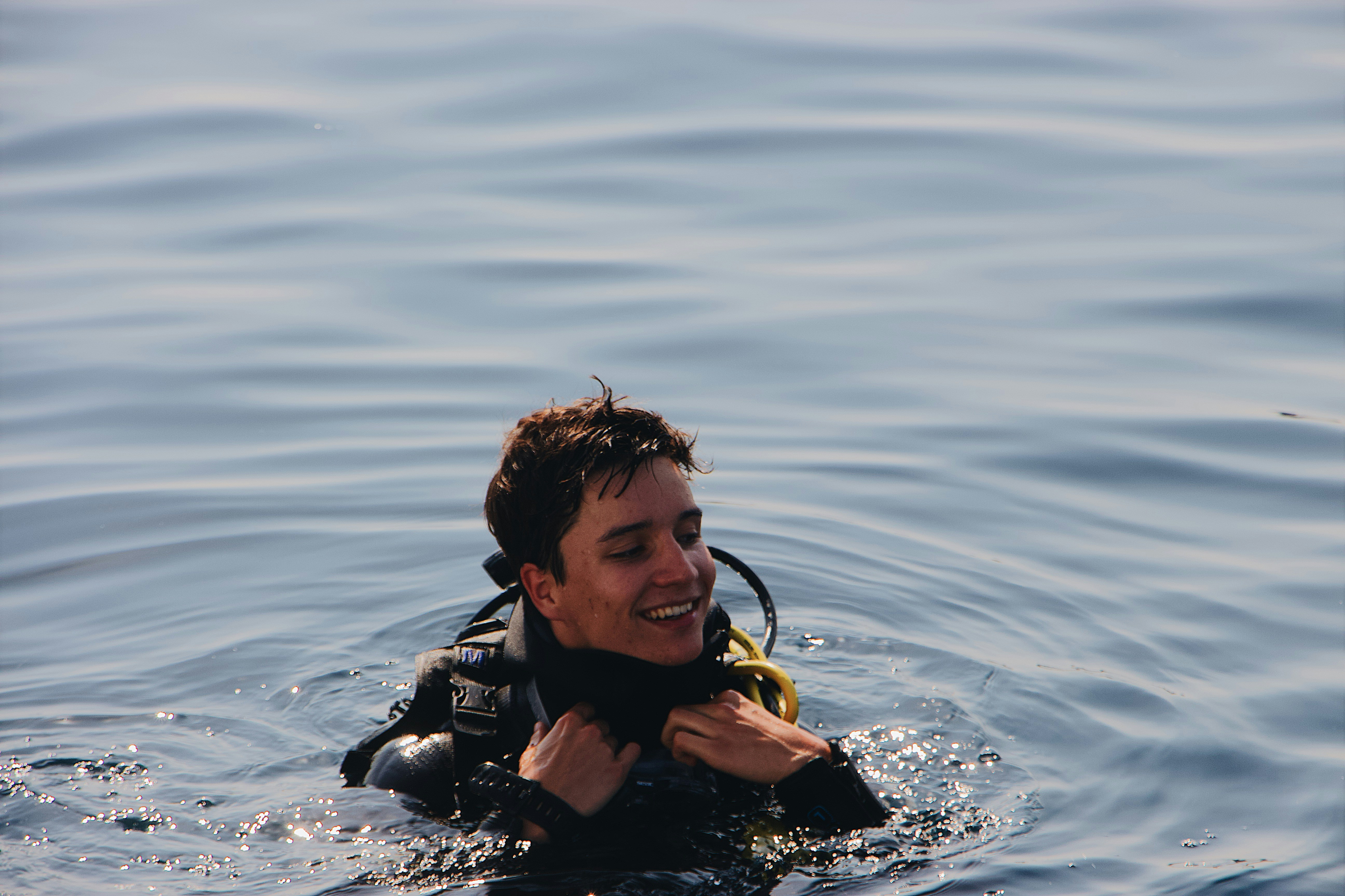 Joy Beneath the Surface: A Diver Smiles Through Tranquil Blue Water