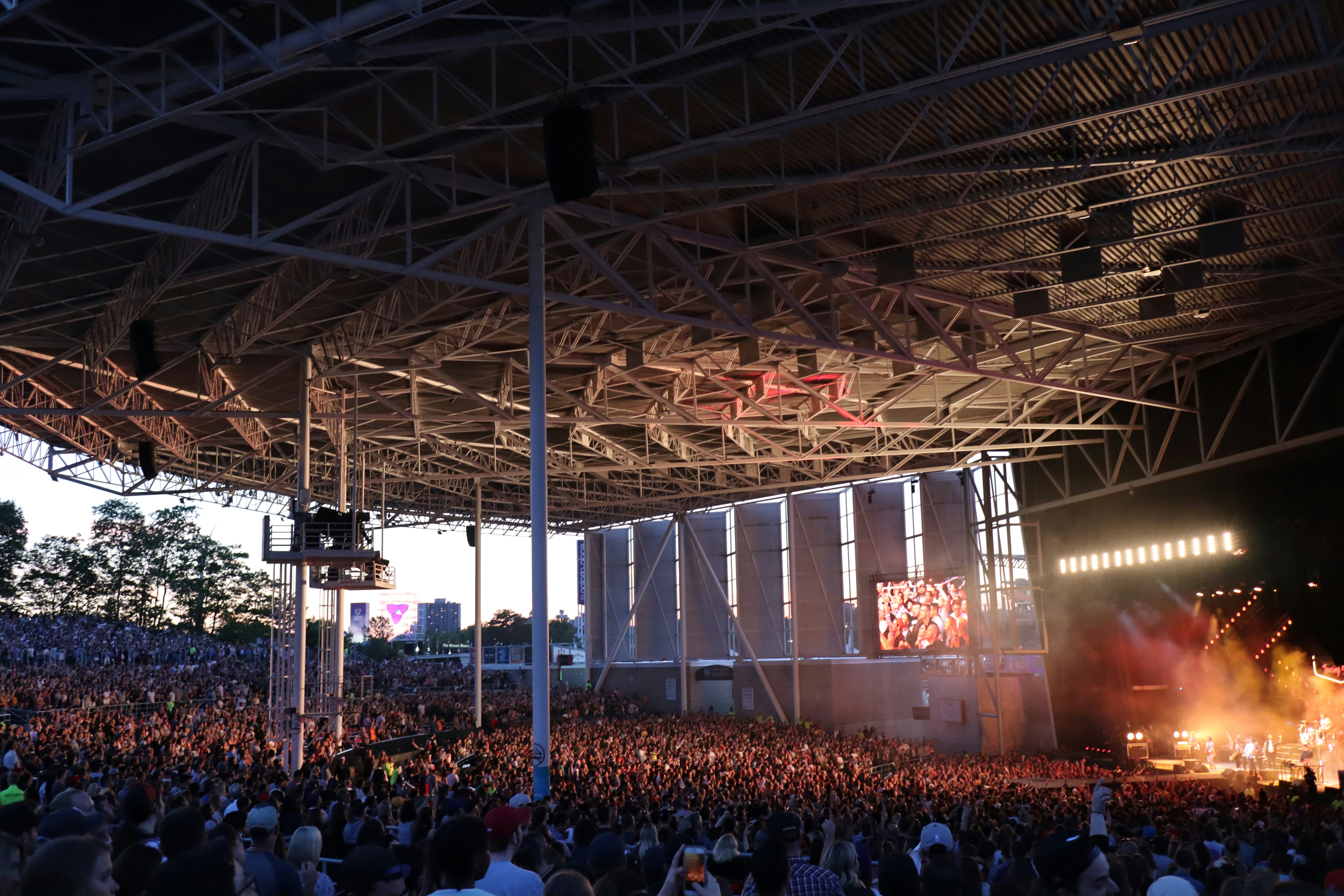 Stage Radiance Over a Sea of Fans in an Open-Air Arena