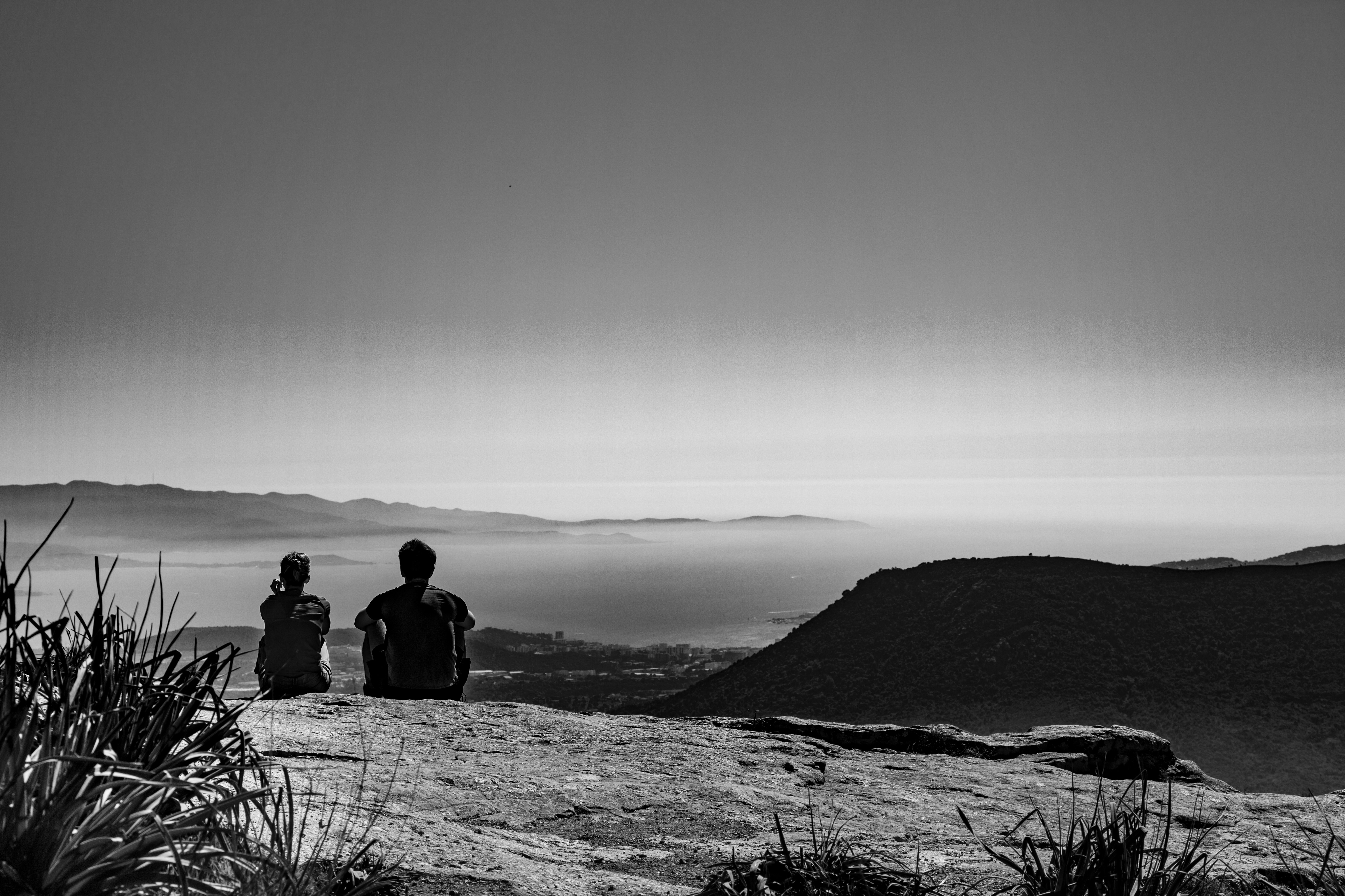 Two person siting side by side overlooking sea photo – Free Grey Image ...