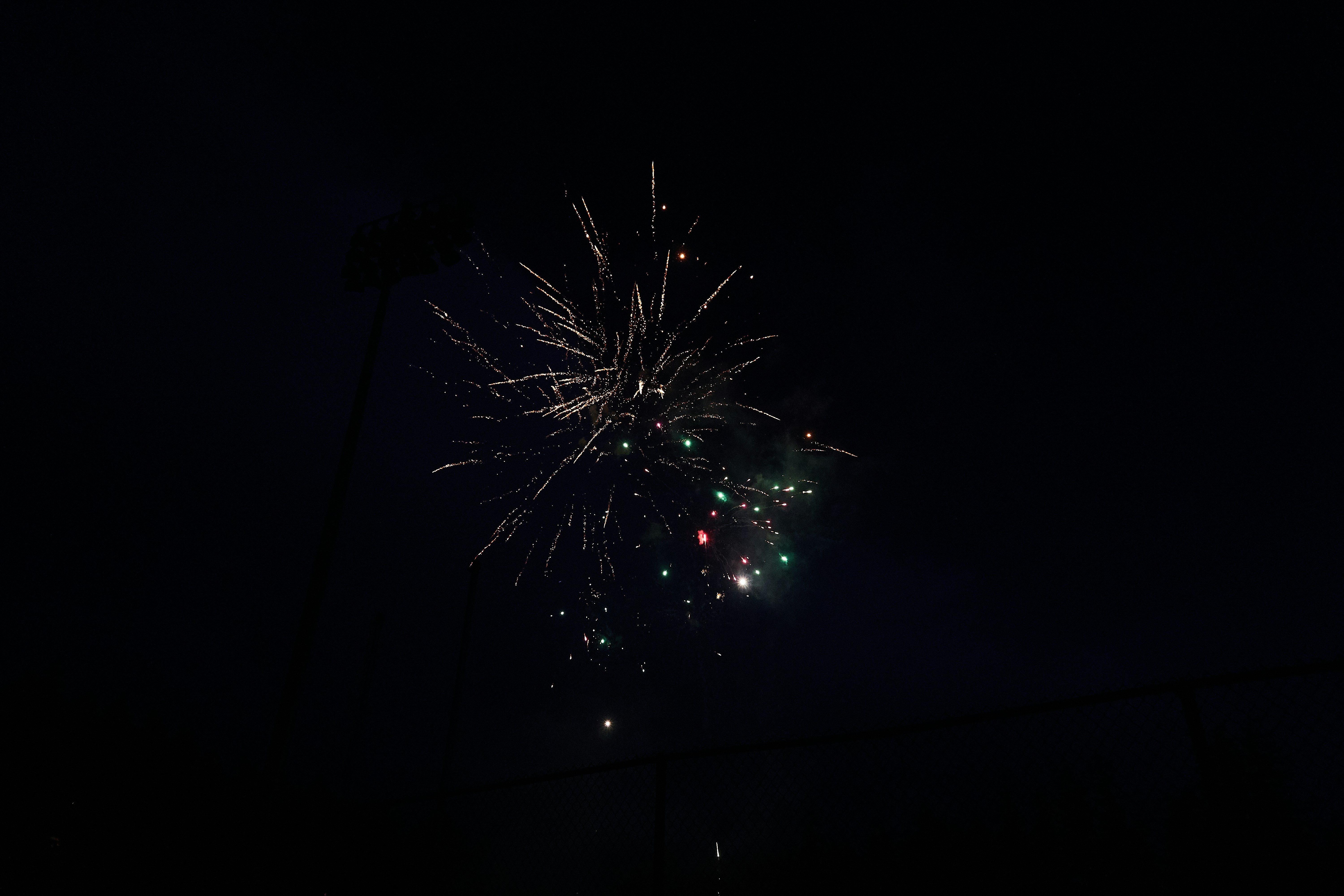 Vibrant fireworks erupting in the night sky, illuminating the darkness with a cascade of colors and sparks.