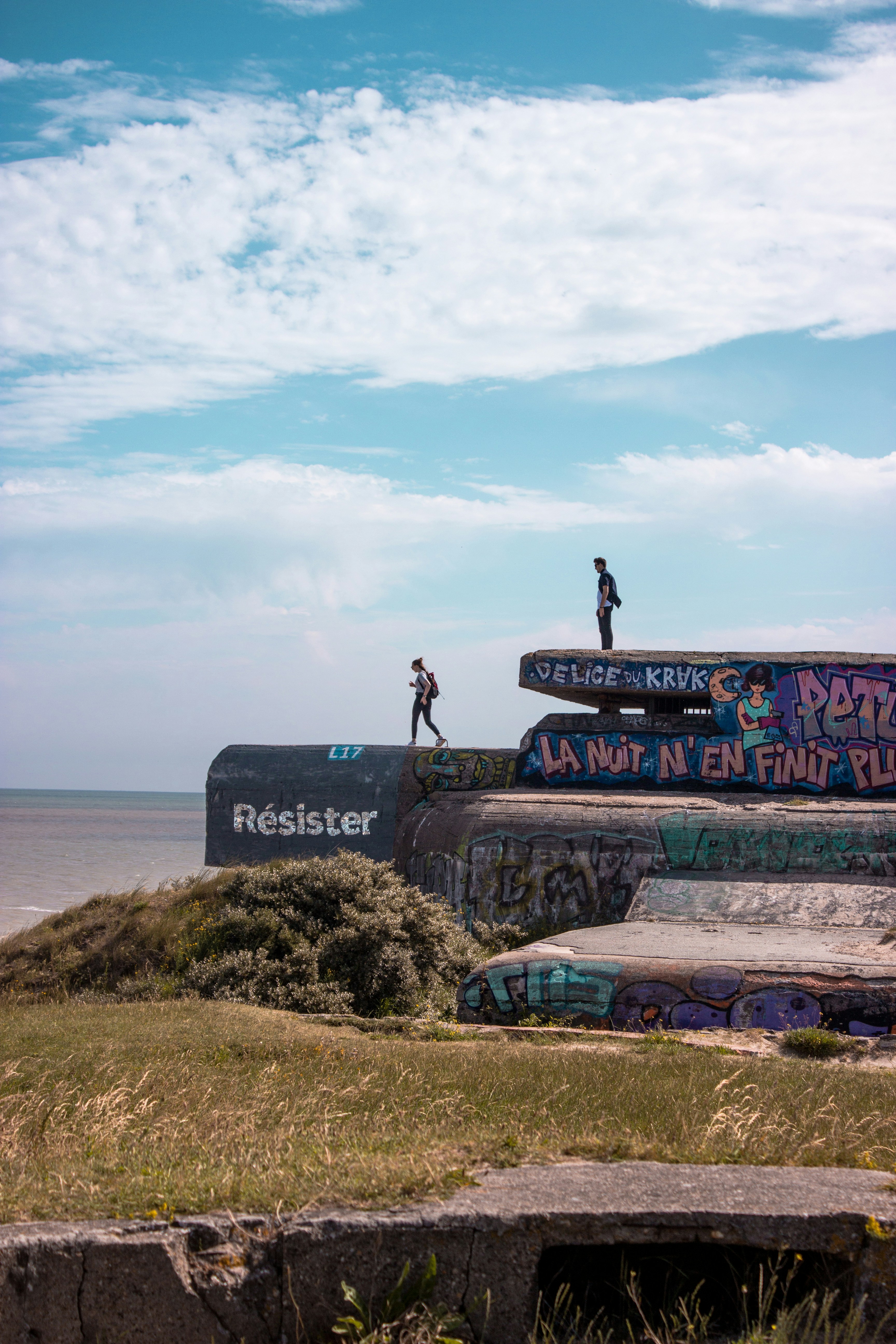 Two men standing on top of ramps in park facing sea photo – Free Blue ...