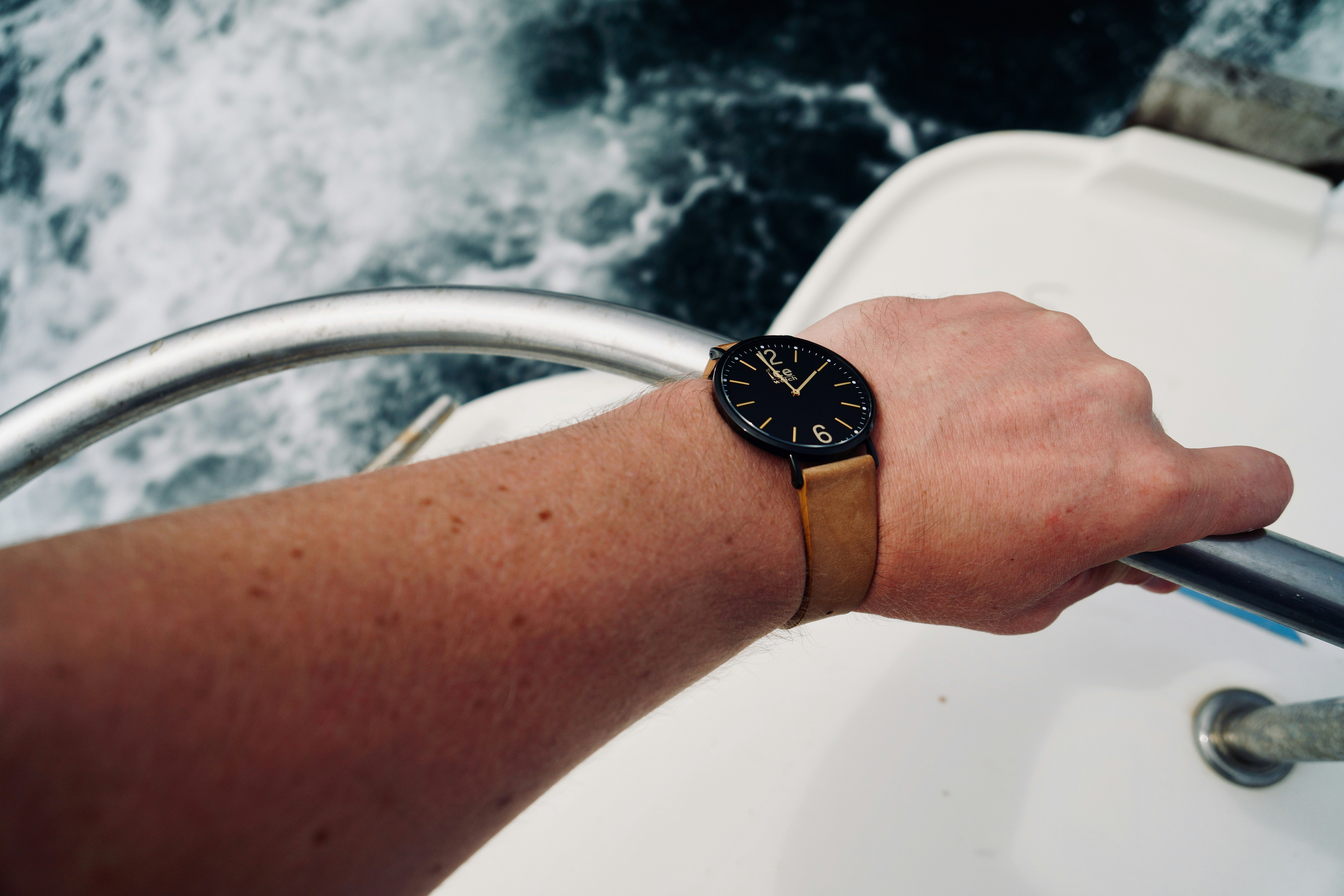 Time on a Quiet Deck: A Wood Swath and Wristwatch on a Distant Ocean Rail