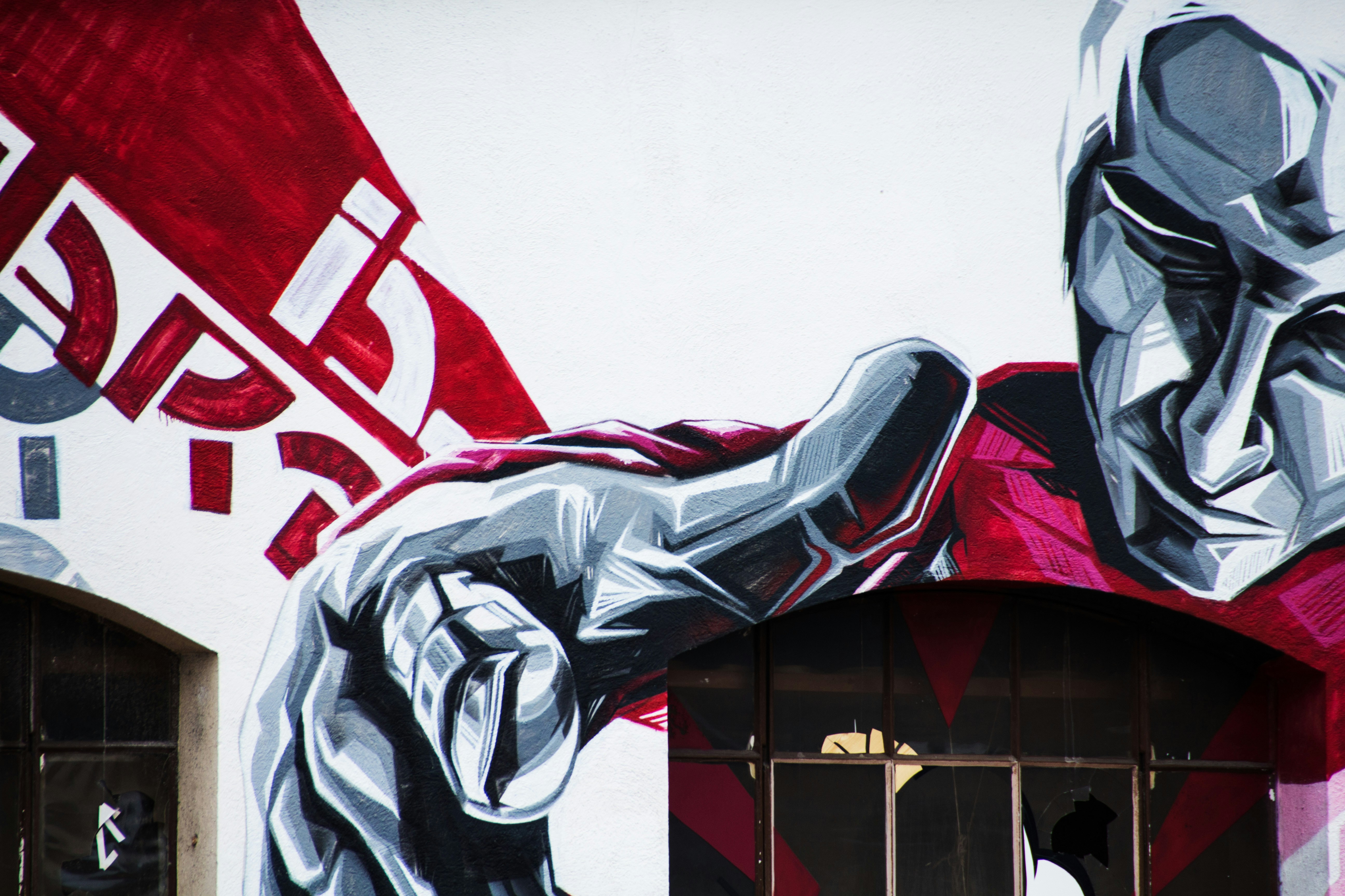Chrome Titan Reaches Out Across a White-Walled Graffiti Mural