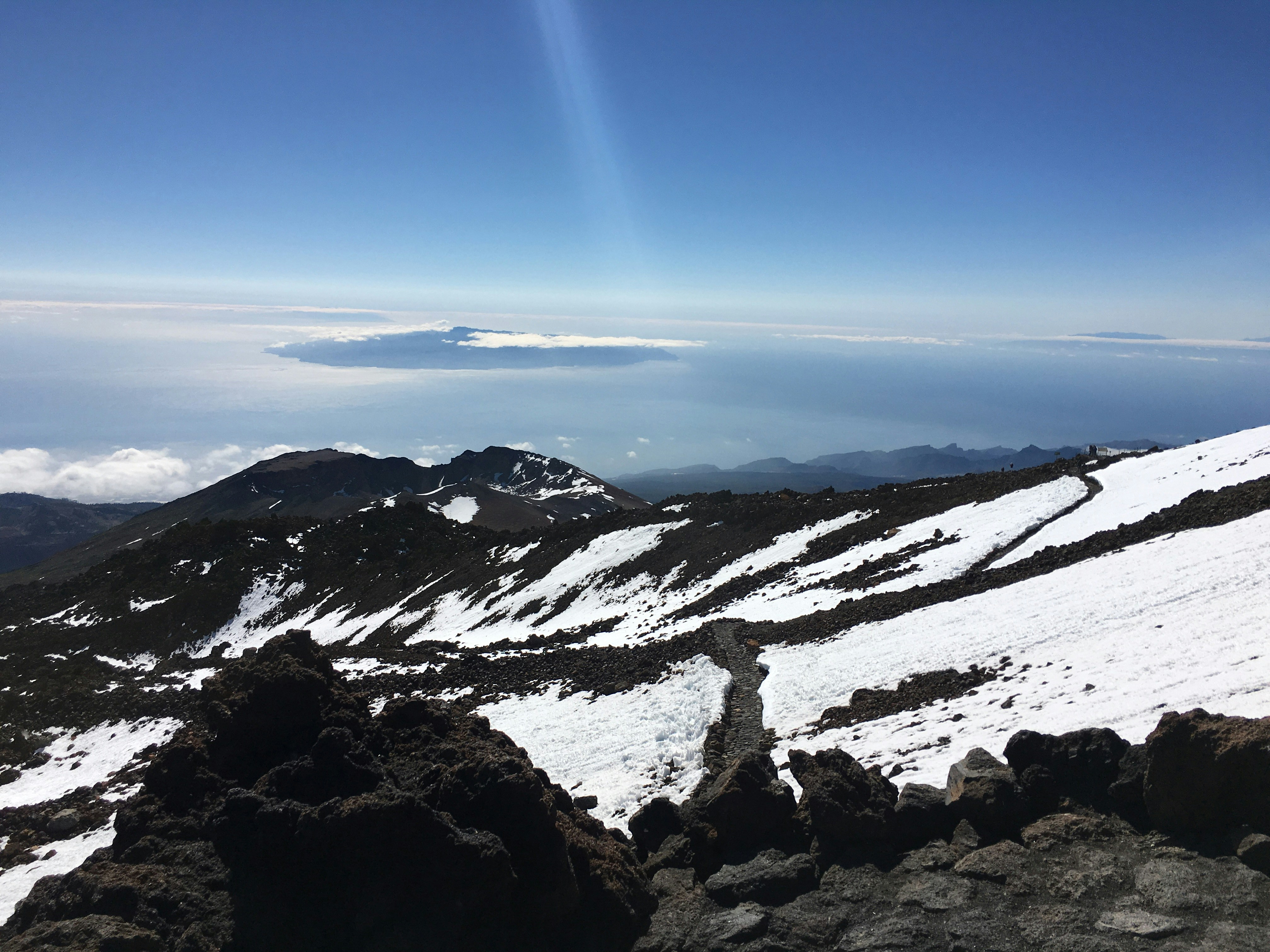 Volcanic Ridge: Snow-Dusted Slopes Stretching Toward a Distant Sea