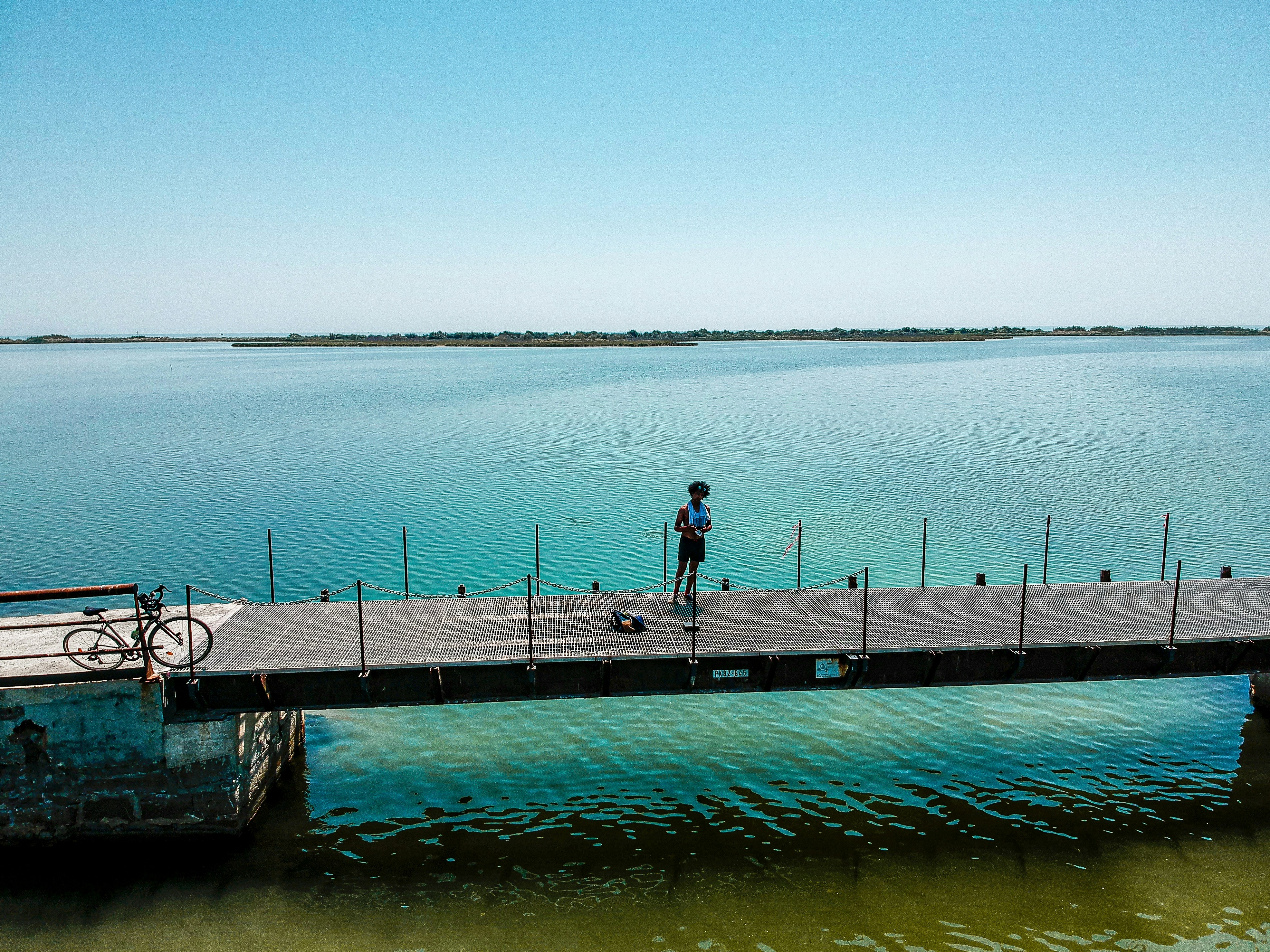 Solitary Angler on a Quiet Canal Pier