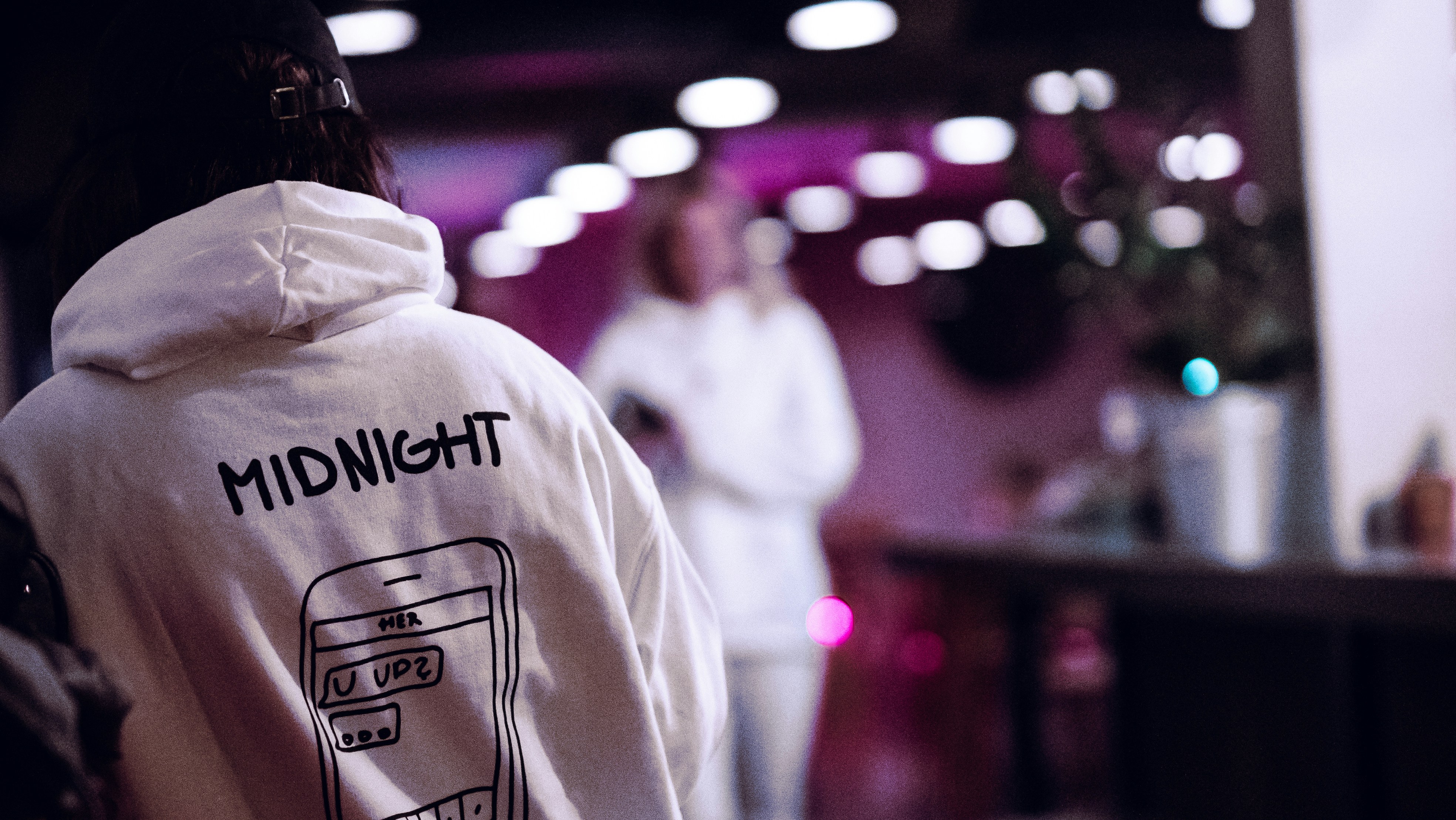 Midnight Hoodie Under Neon Pulse in a Dim Lounge