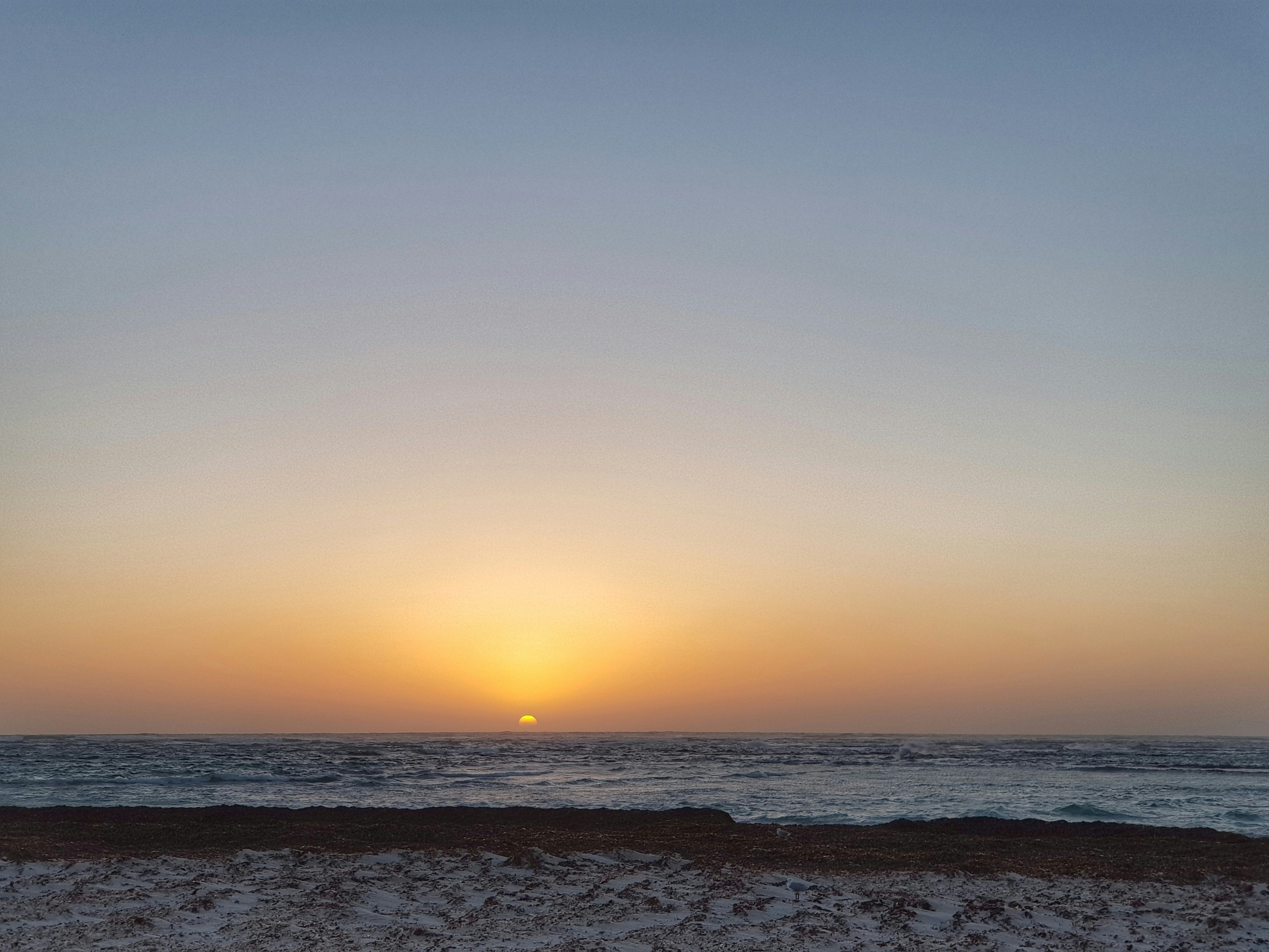 Dawn's Gentle Embrace Over Ocean Waves