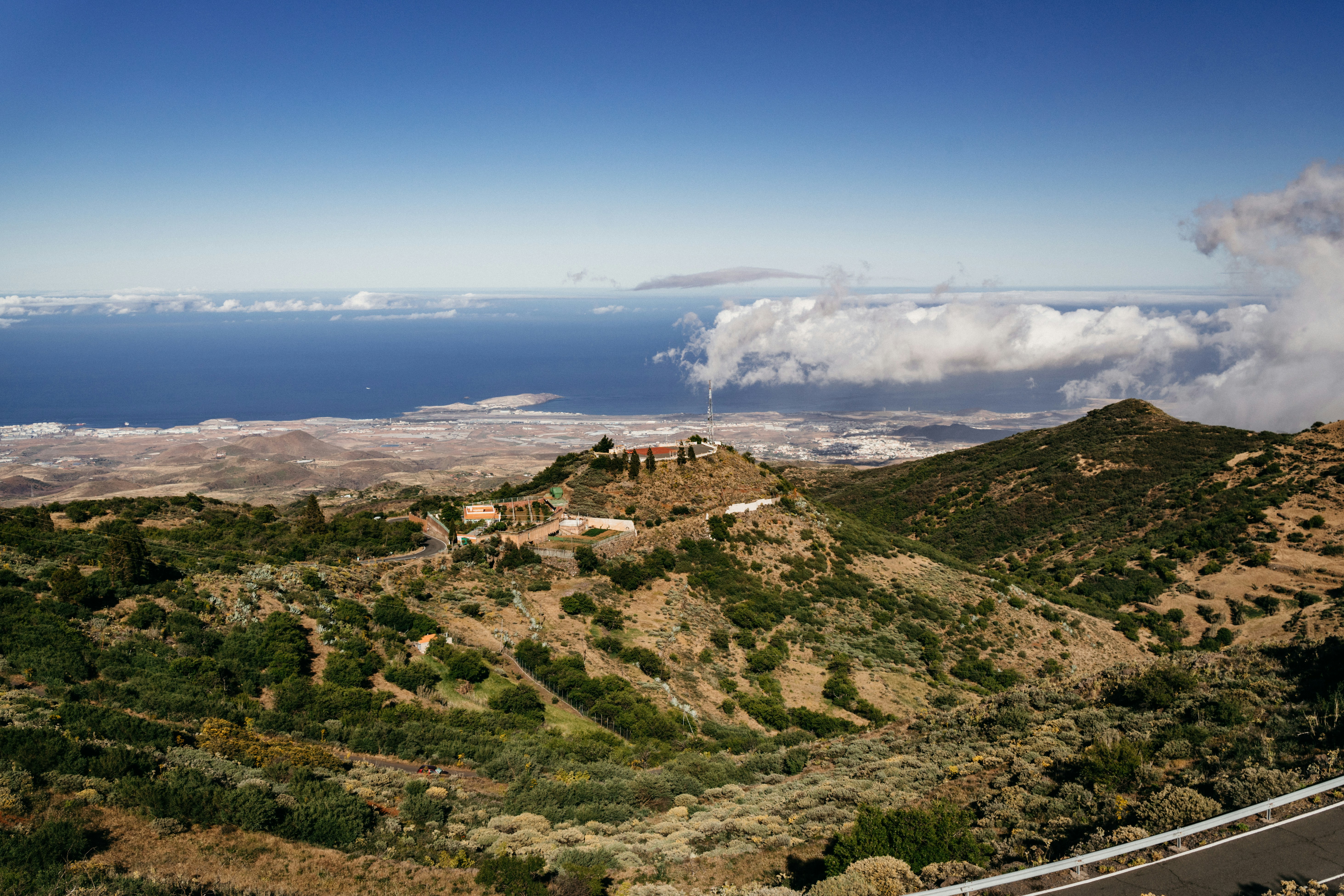 Ridge Overlook: scrubland, guardrail, and a distant sea on the horizon