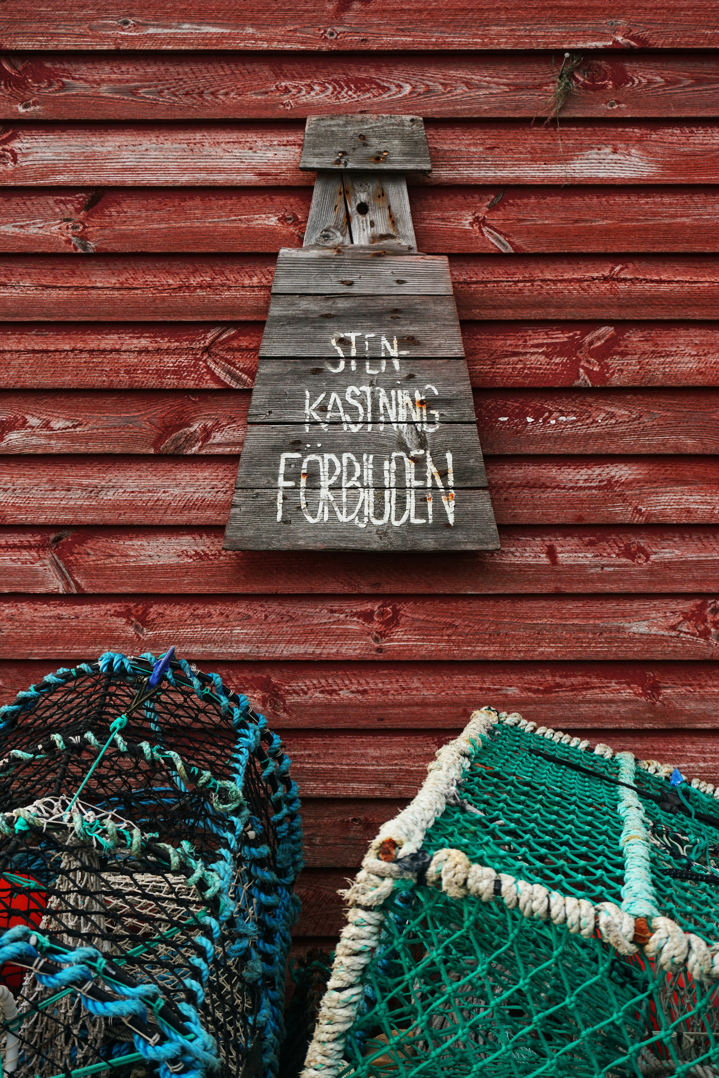 Weathered Sign on a Red Wooden Wall with Marine Crabs