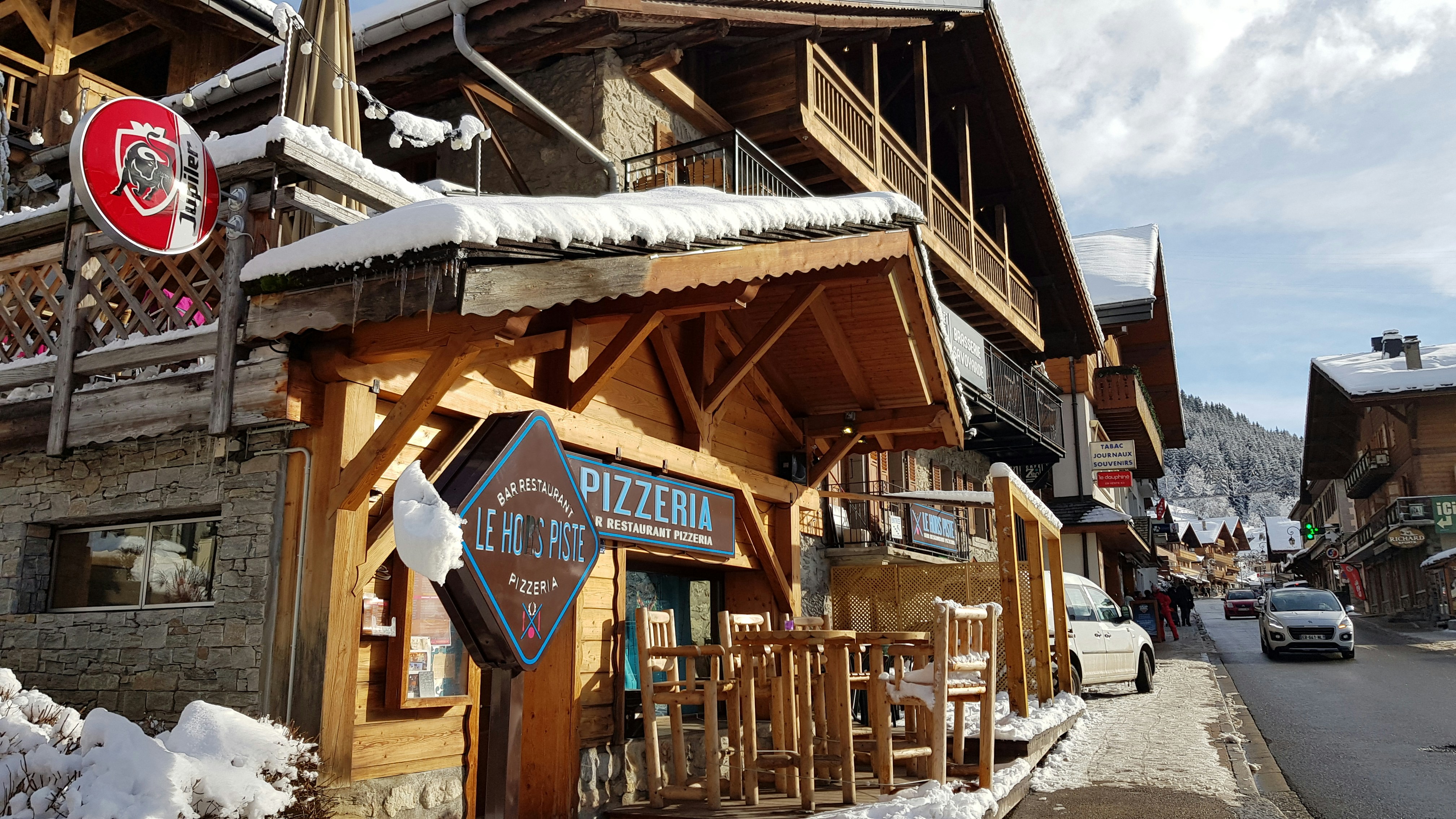 Snow-Dusted Alpine Streetfront with a Sunlit Pizzeria Sign