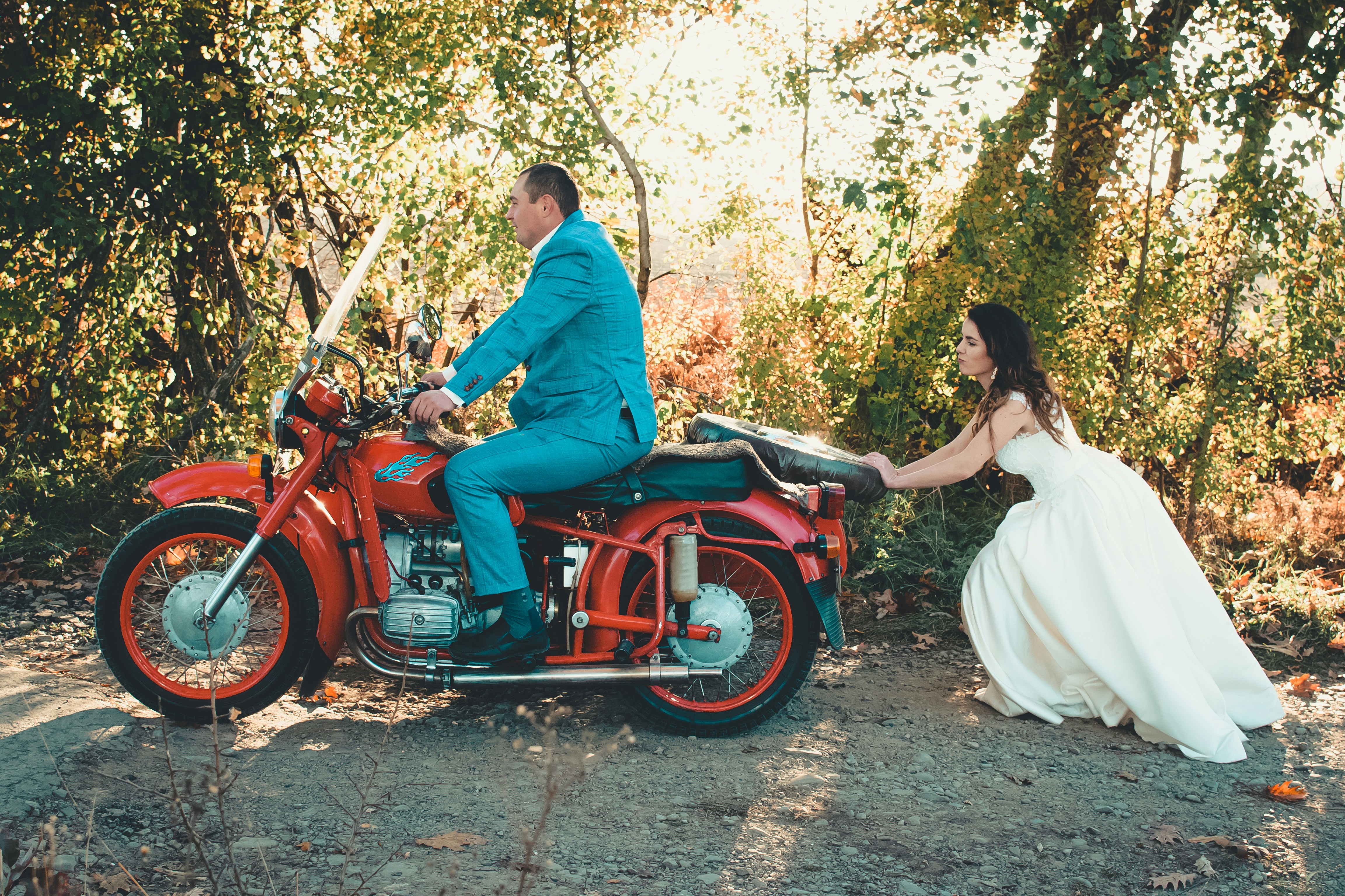 Vows on a Red Vintage Motorcycle: Bride and Groom in a Sunlit Forest