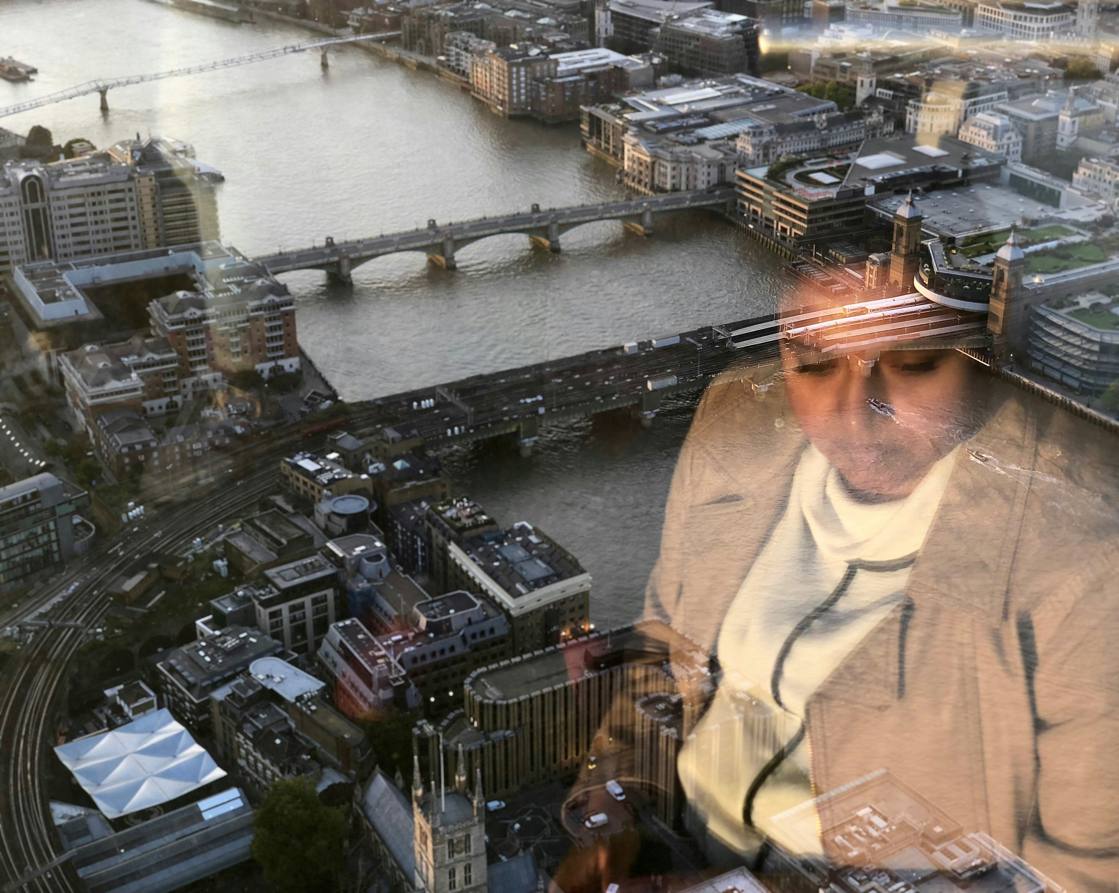 Overlaid Cityscape: The Reflective Portrait Within a Glassy Sky