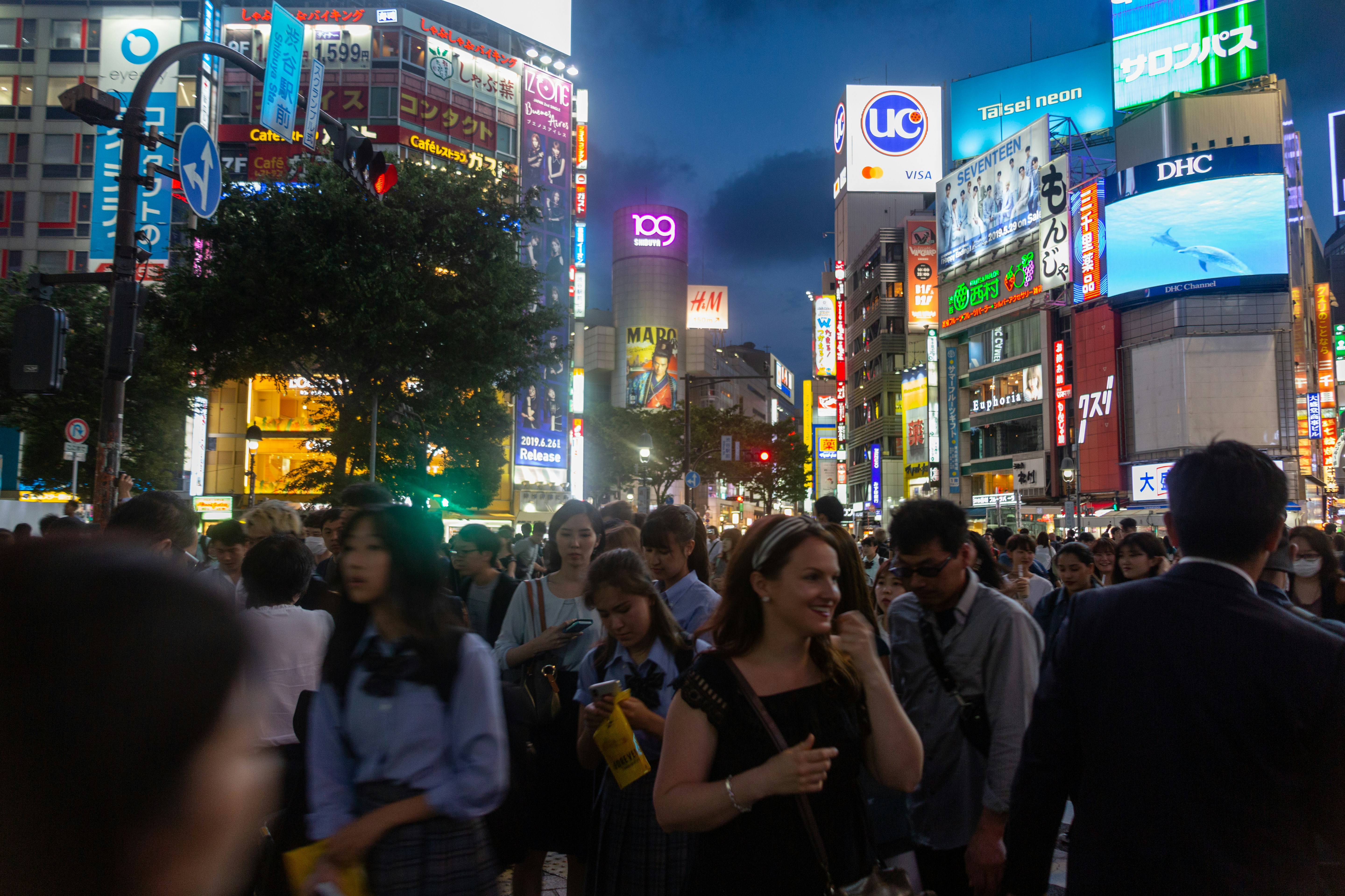 Neon Crossroads: Faces Amid Tokyo's Night-Billboard Tide