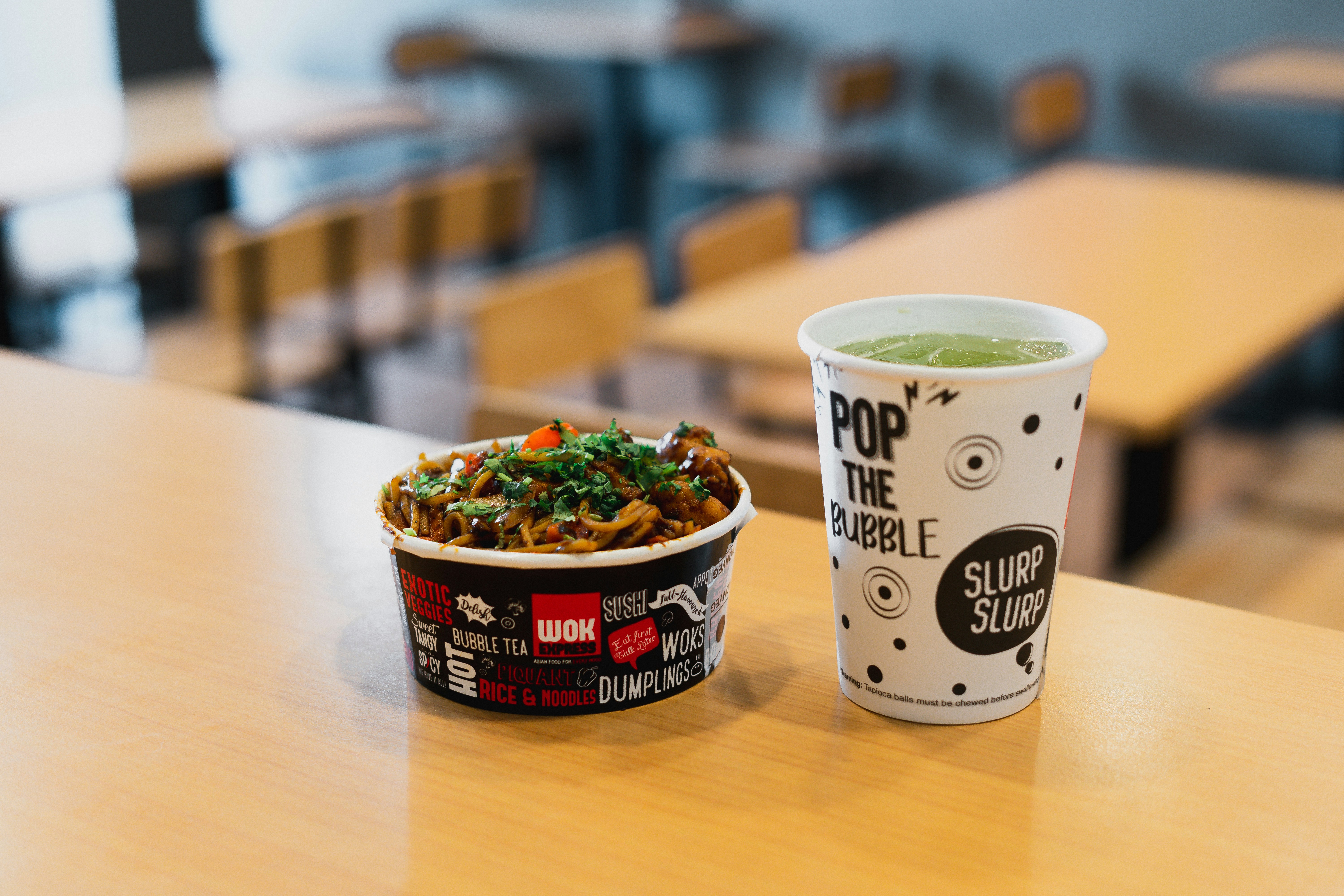 Steam-kissed Bowl and Green Tea in a Cozy Cafeteria
