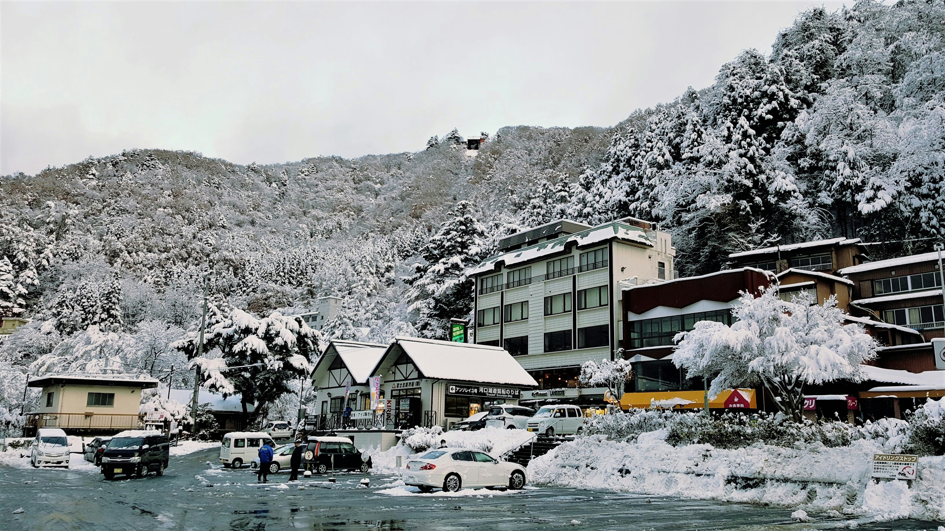 Snow-laden buildings nestled against a mountainous backdrop, showcasing a serene winter scene. The tranquil atmosphere invites exploration and relaxation.