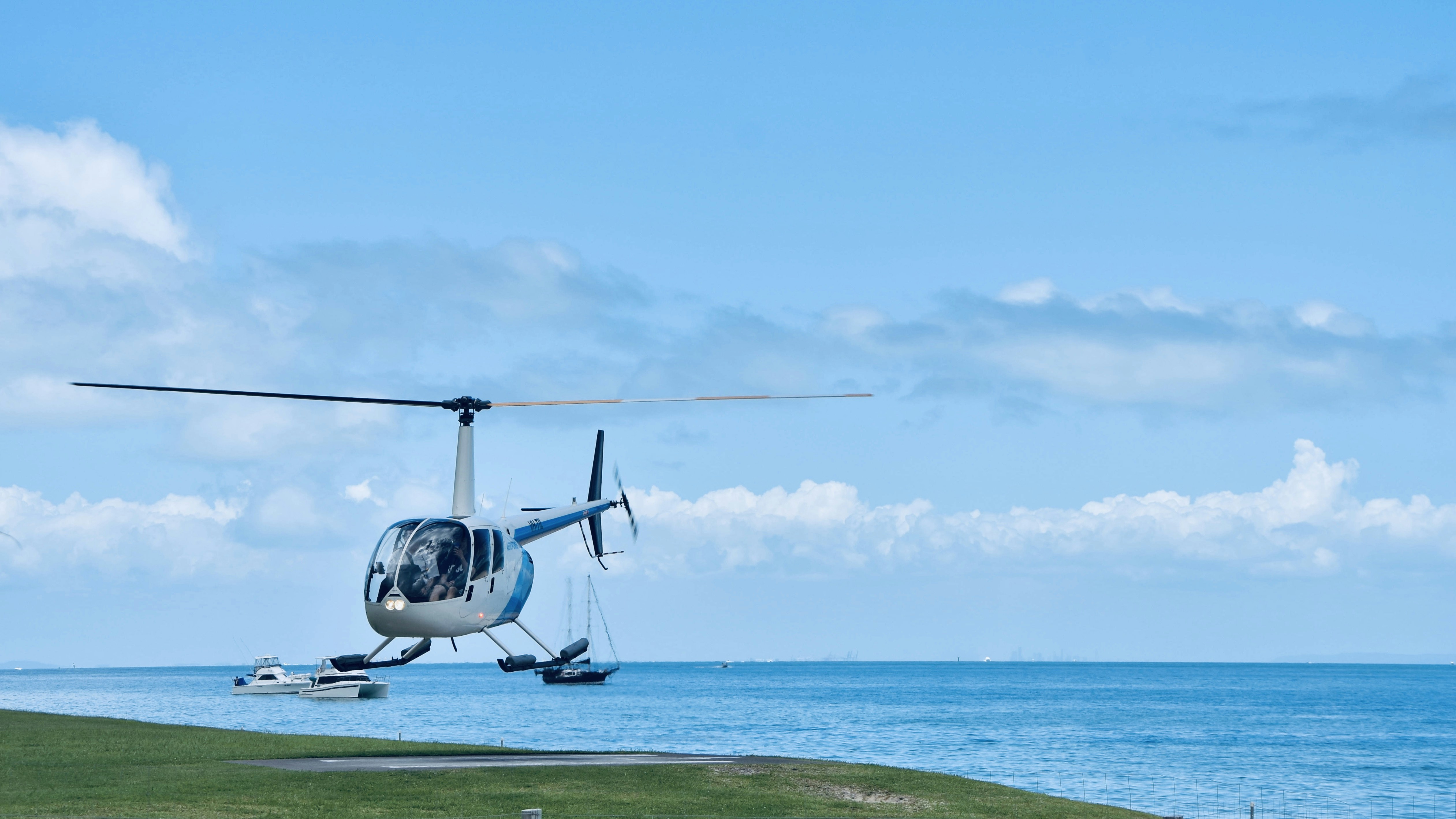 White helicopter on grassy cliff photo – Free Blue Image on Unsplash