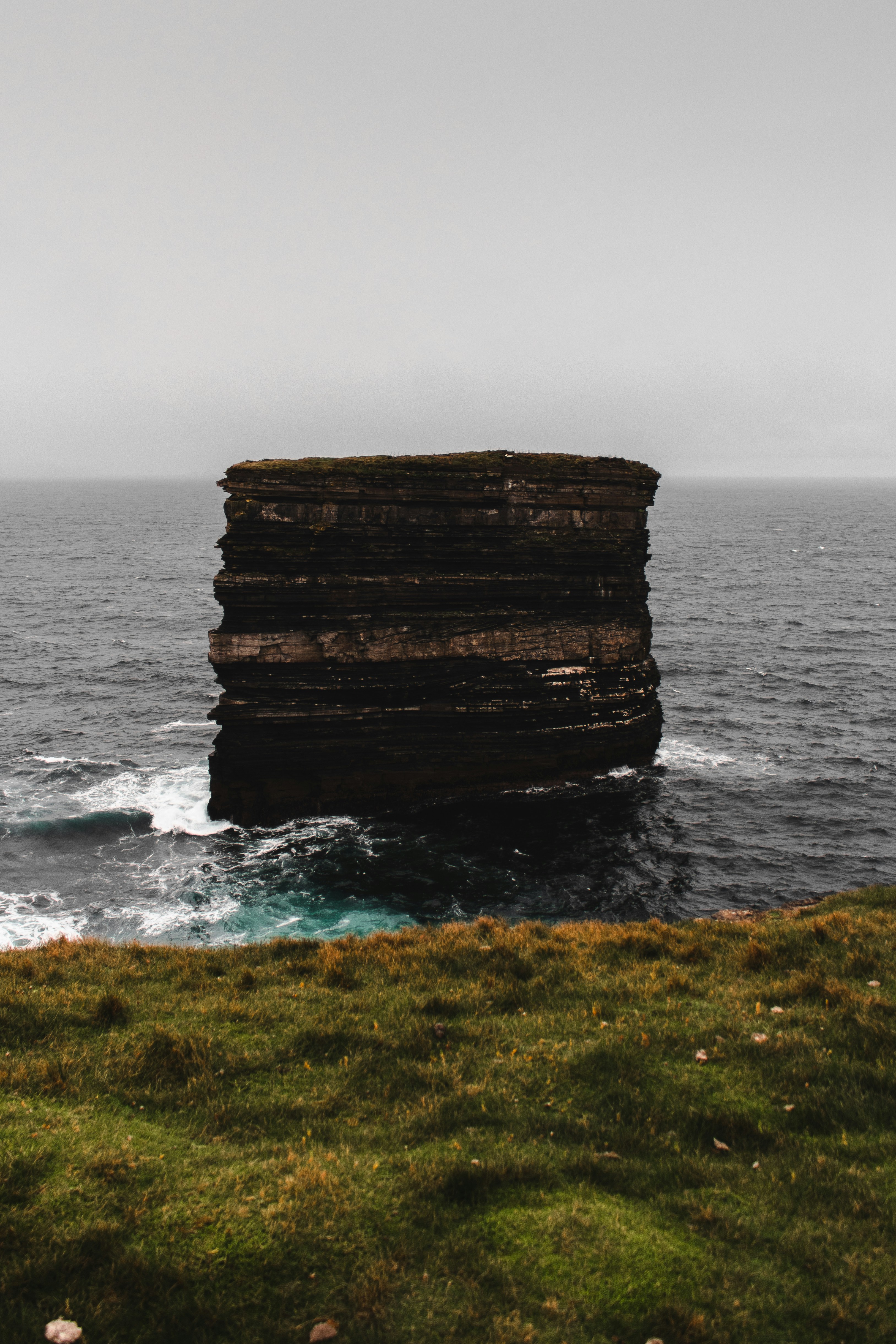 Foto Formación de tierra gris en el mar bajo el cielo blanco – Imagen ...