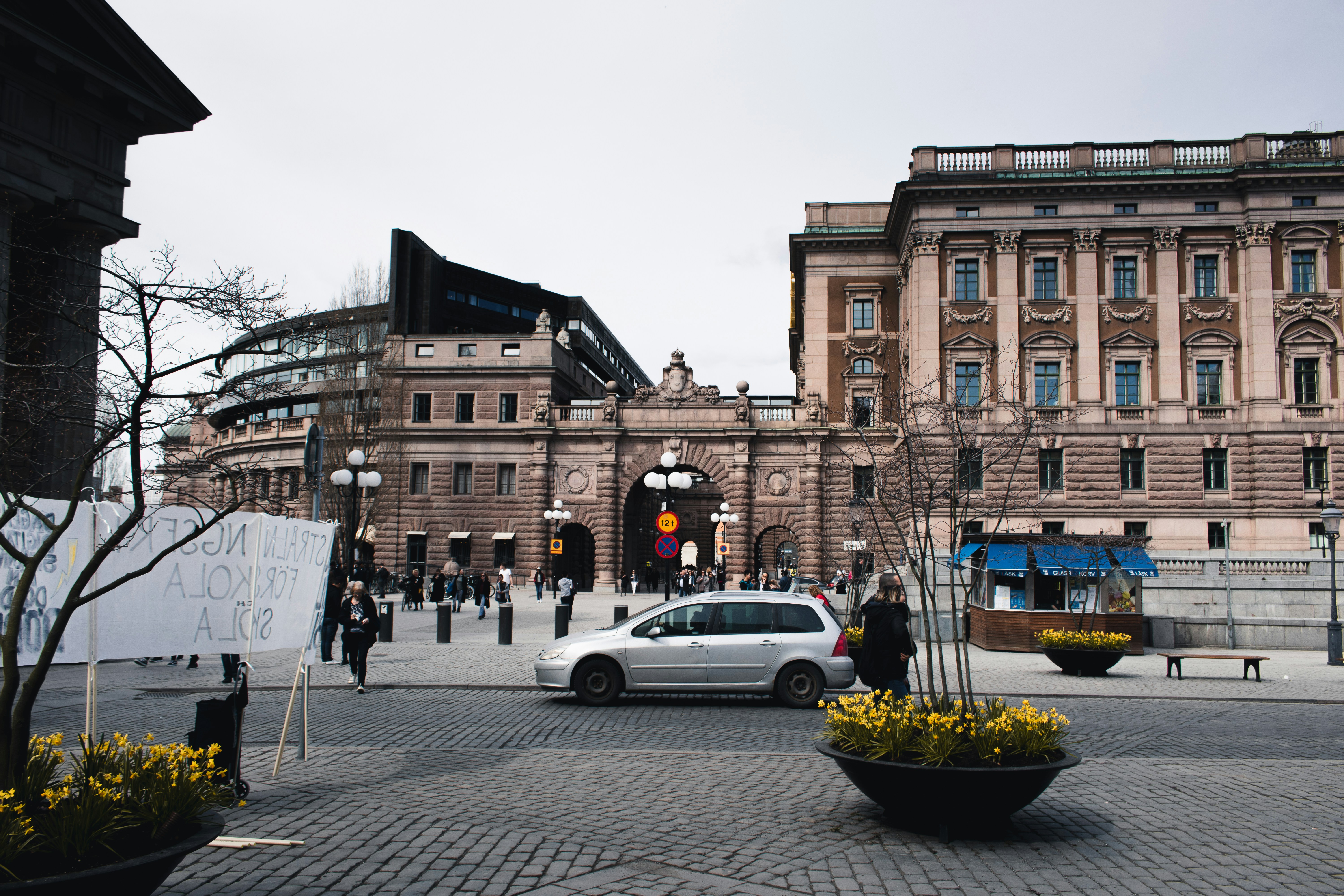 White Car at the Archway Plaza: A Quiet Convergence of Modern Mobility and Historic Facades