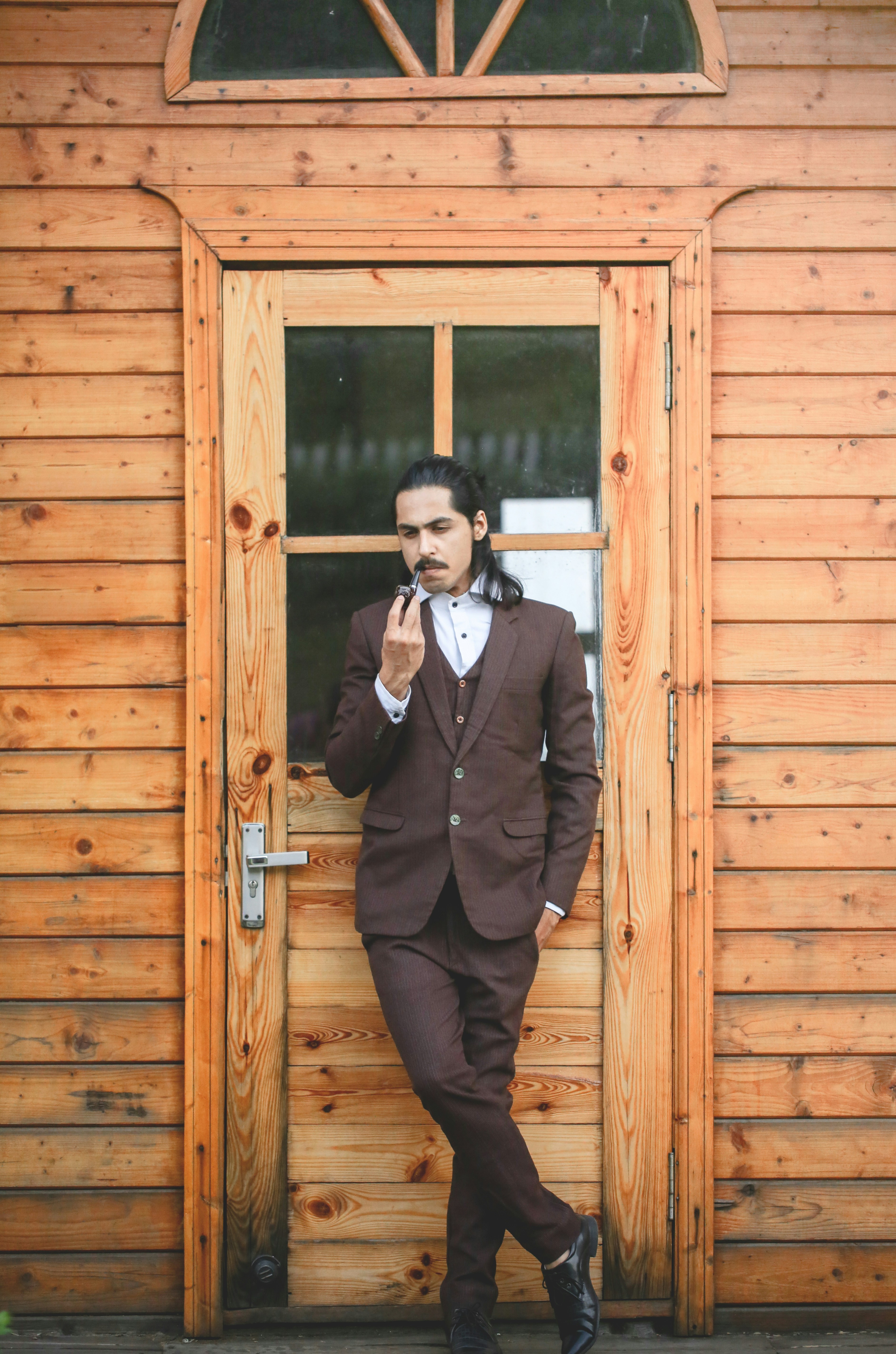 Pinstripe at the Portal: A Suited Moment by the Wooden Door