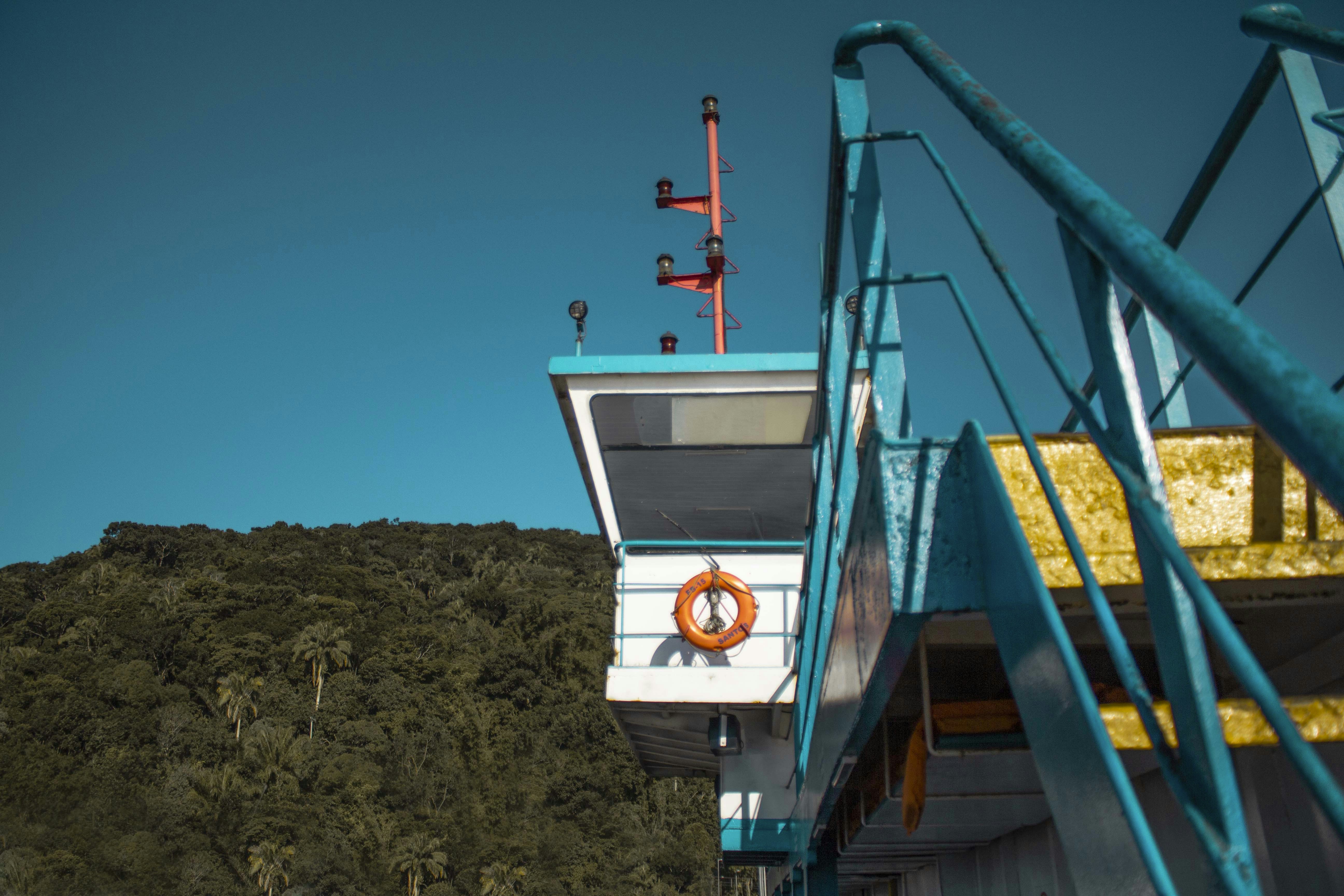 Lifebuoy on a Blue Pier: Quiet Geometry against Forested Backdrop