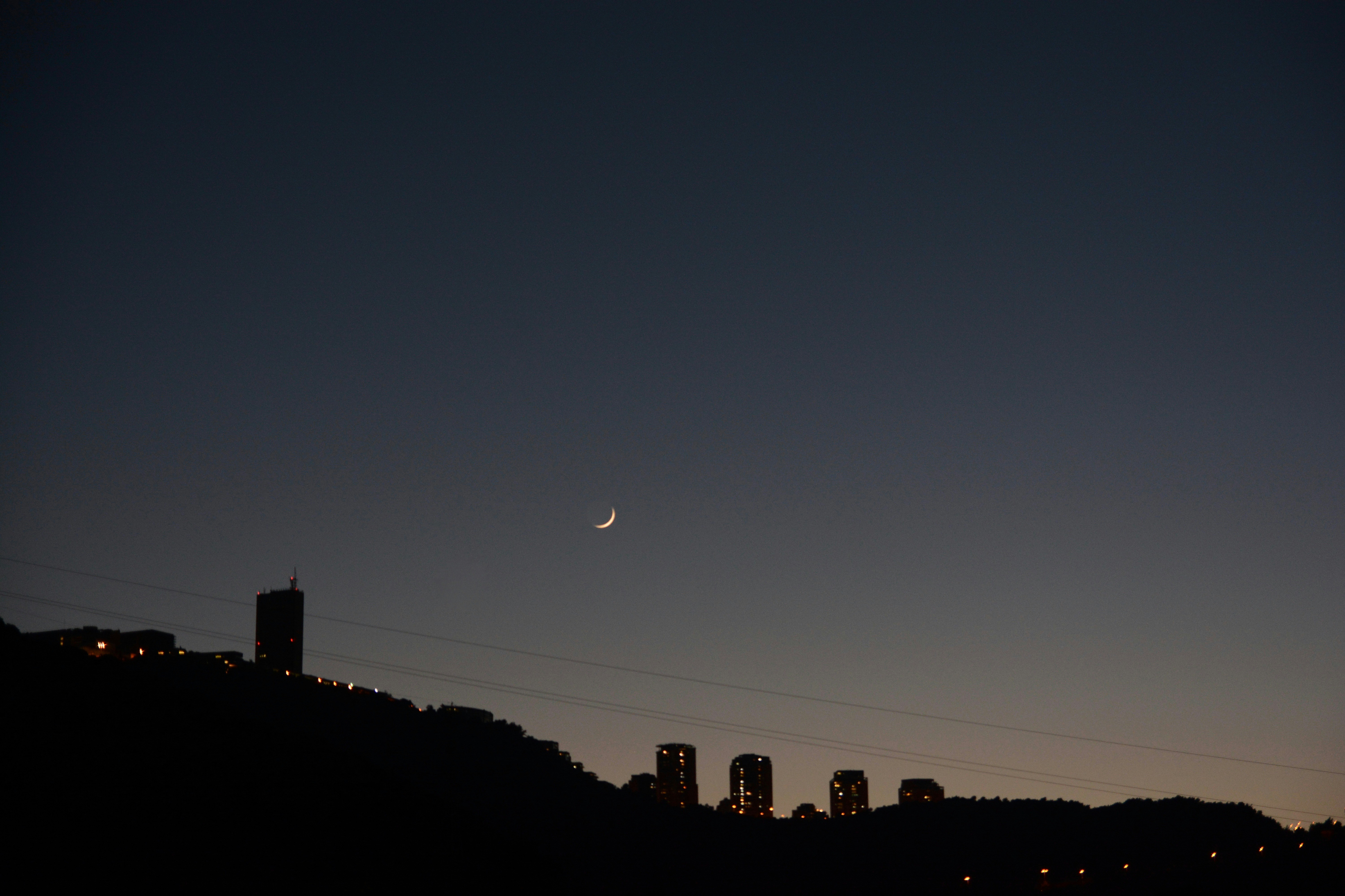 The moon is setting over the city skyline photo – Free Grey Image on ...
