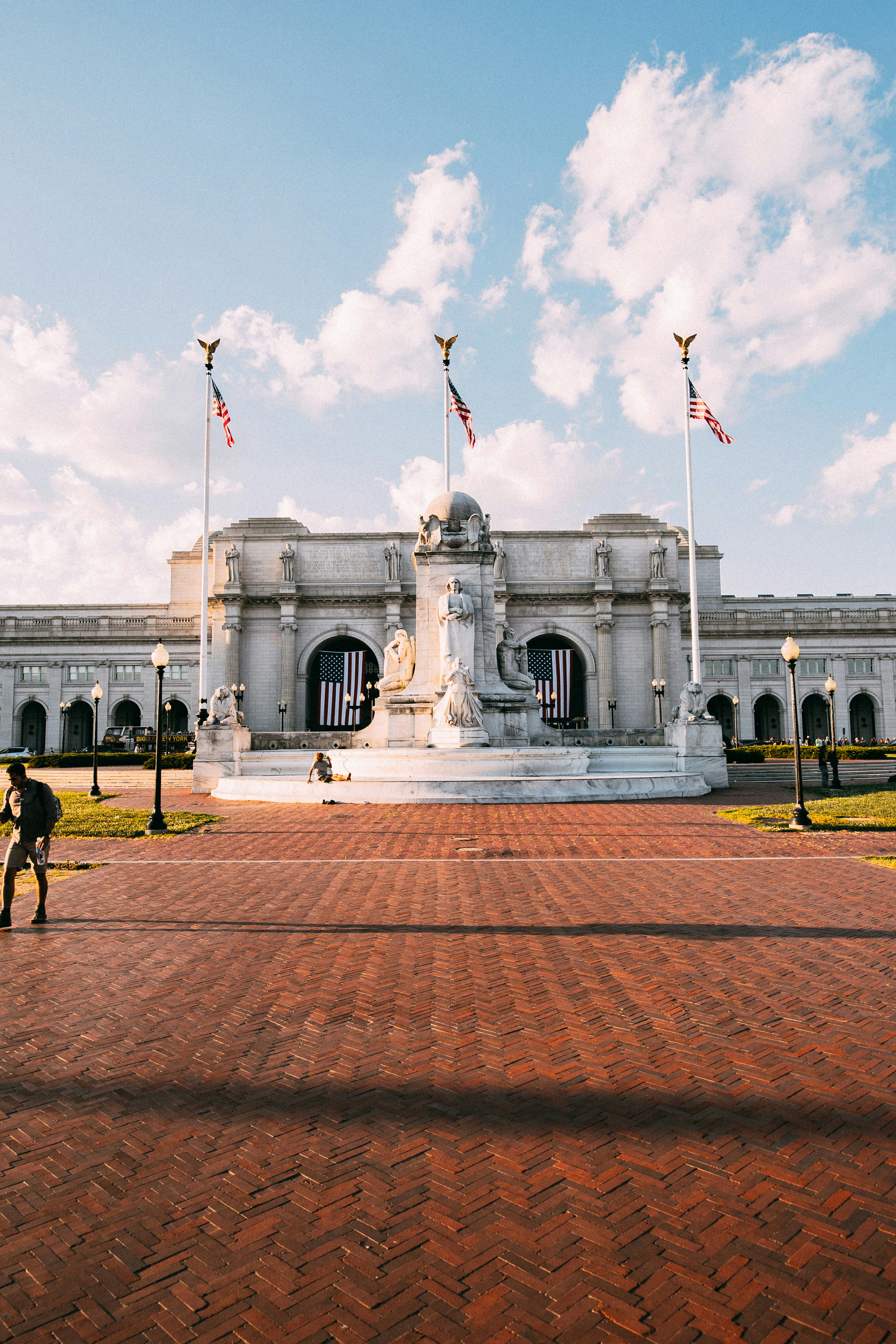 Elegant fountain surrounded by historical architecture and American flags, capturing a moment of tranquility in a bustling city square.