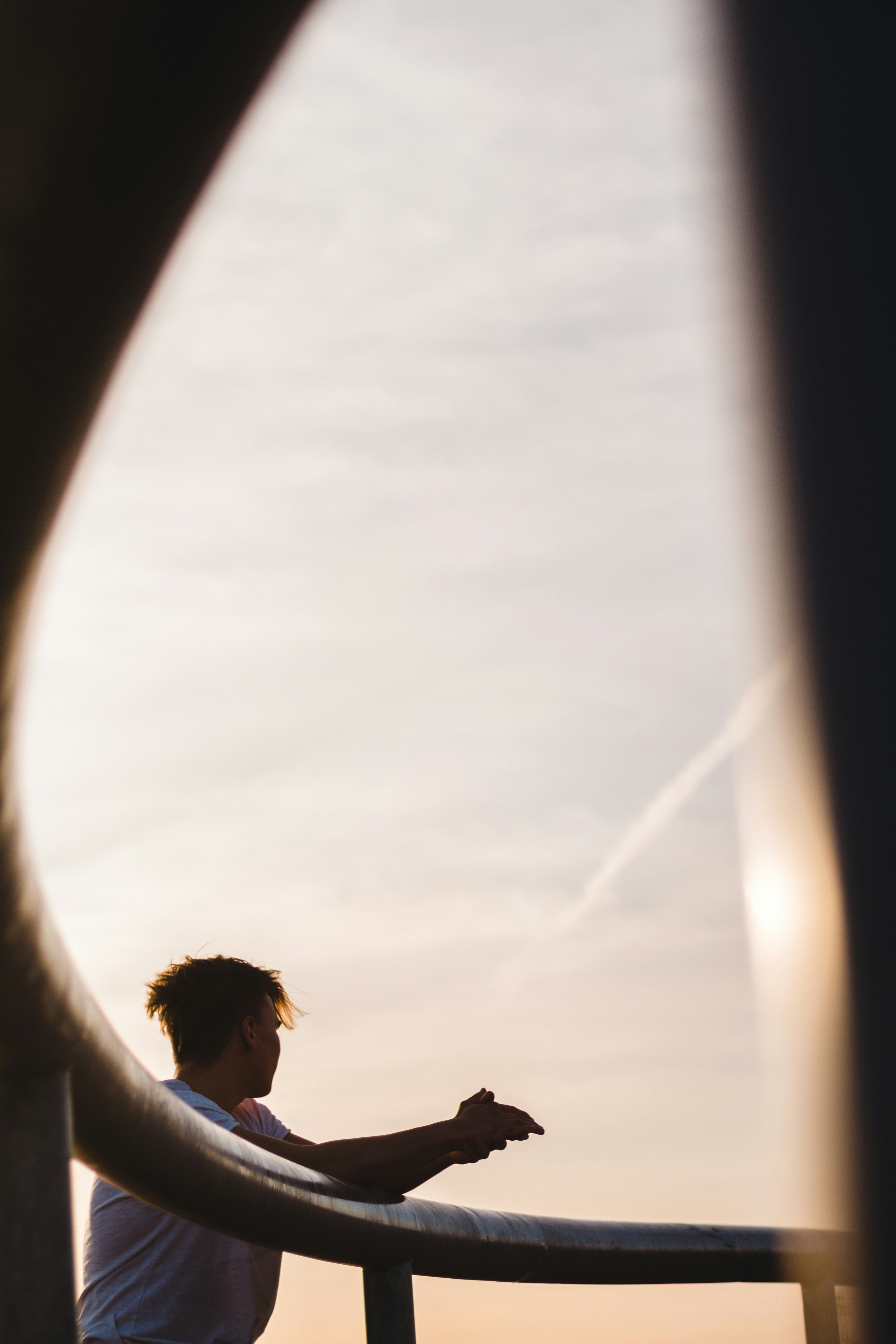 Glimmer on the Rail: A Sunset Silhouette by the Curved Barrier