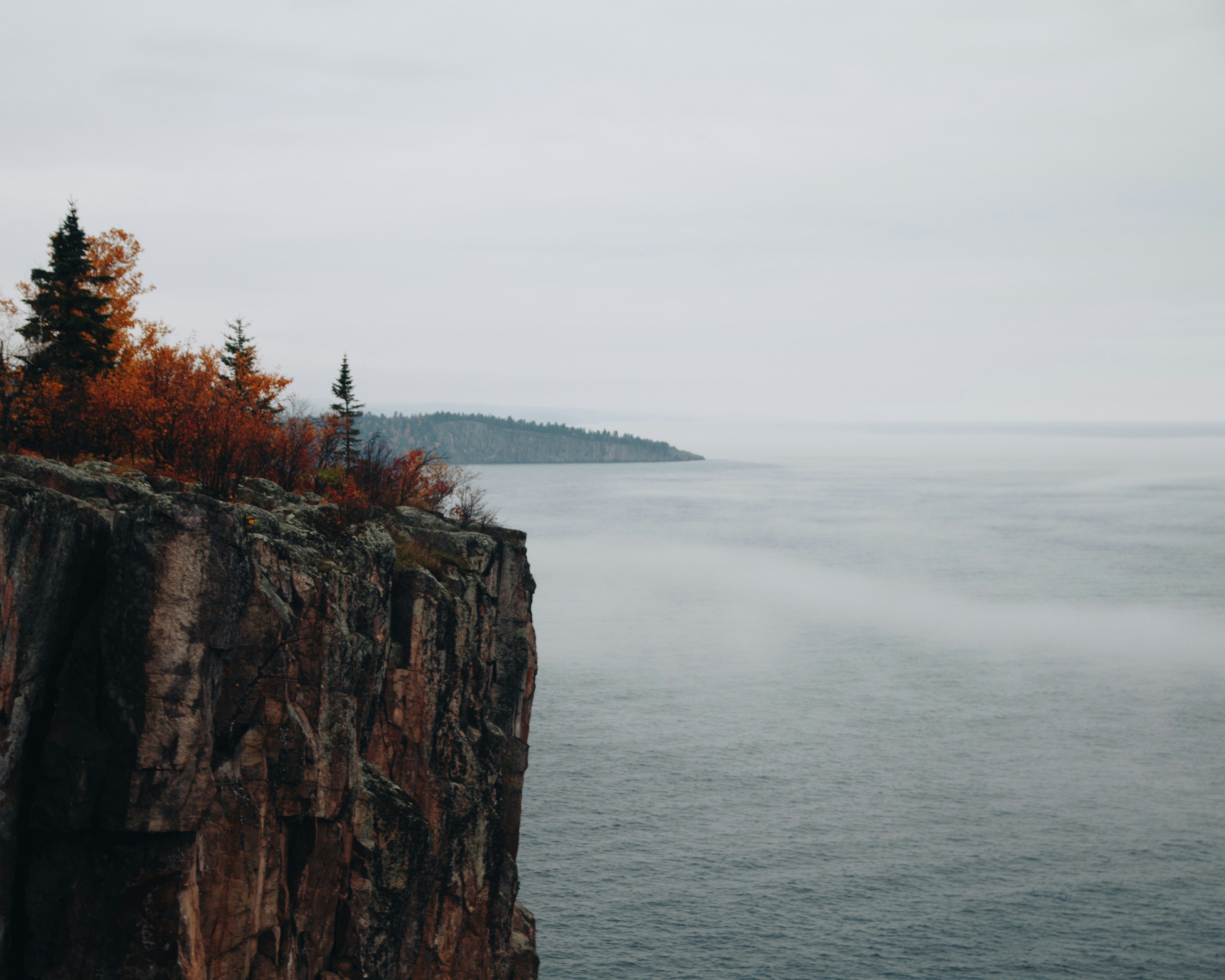Autumn Edge: Cliffside Sentinels Over a Misty Sea