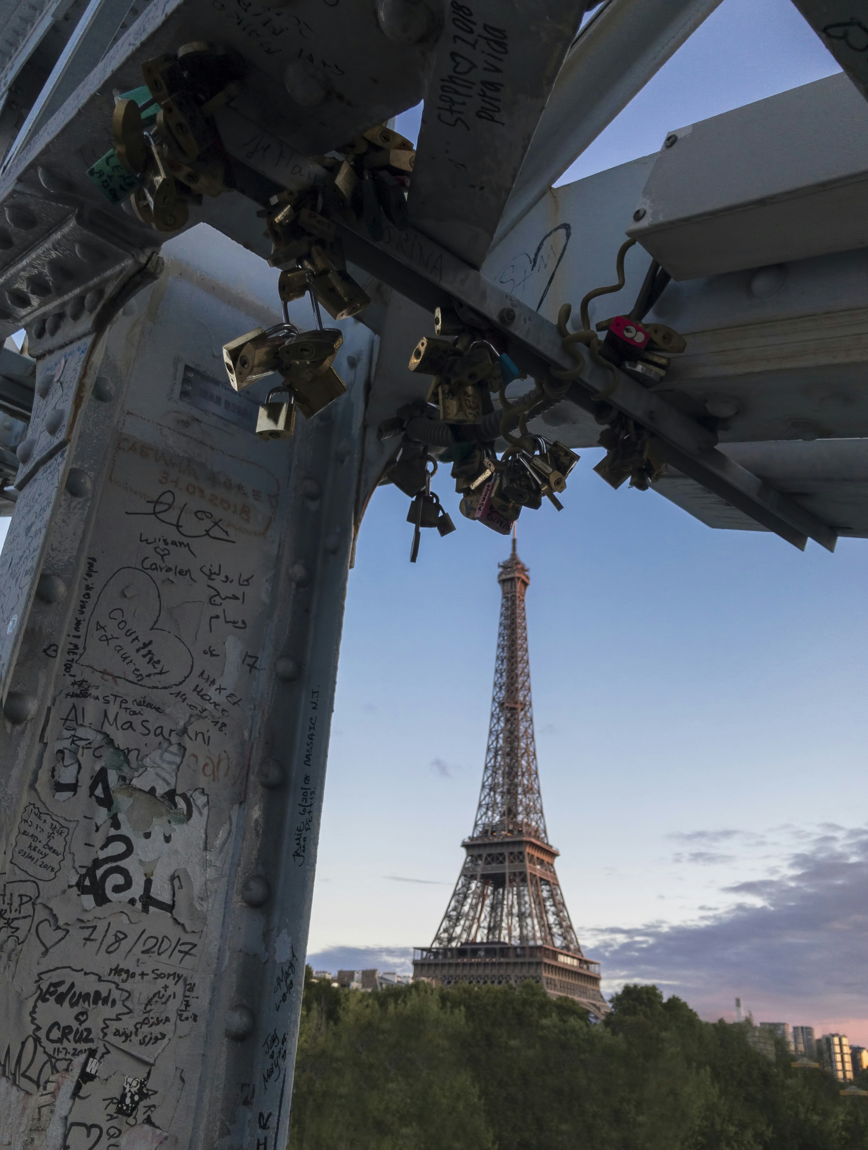 Locks in the Framing: The Eiffel Tower through a Graffiti-Laced Metal Frame