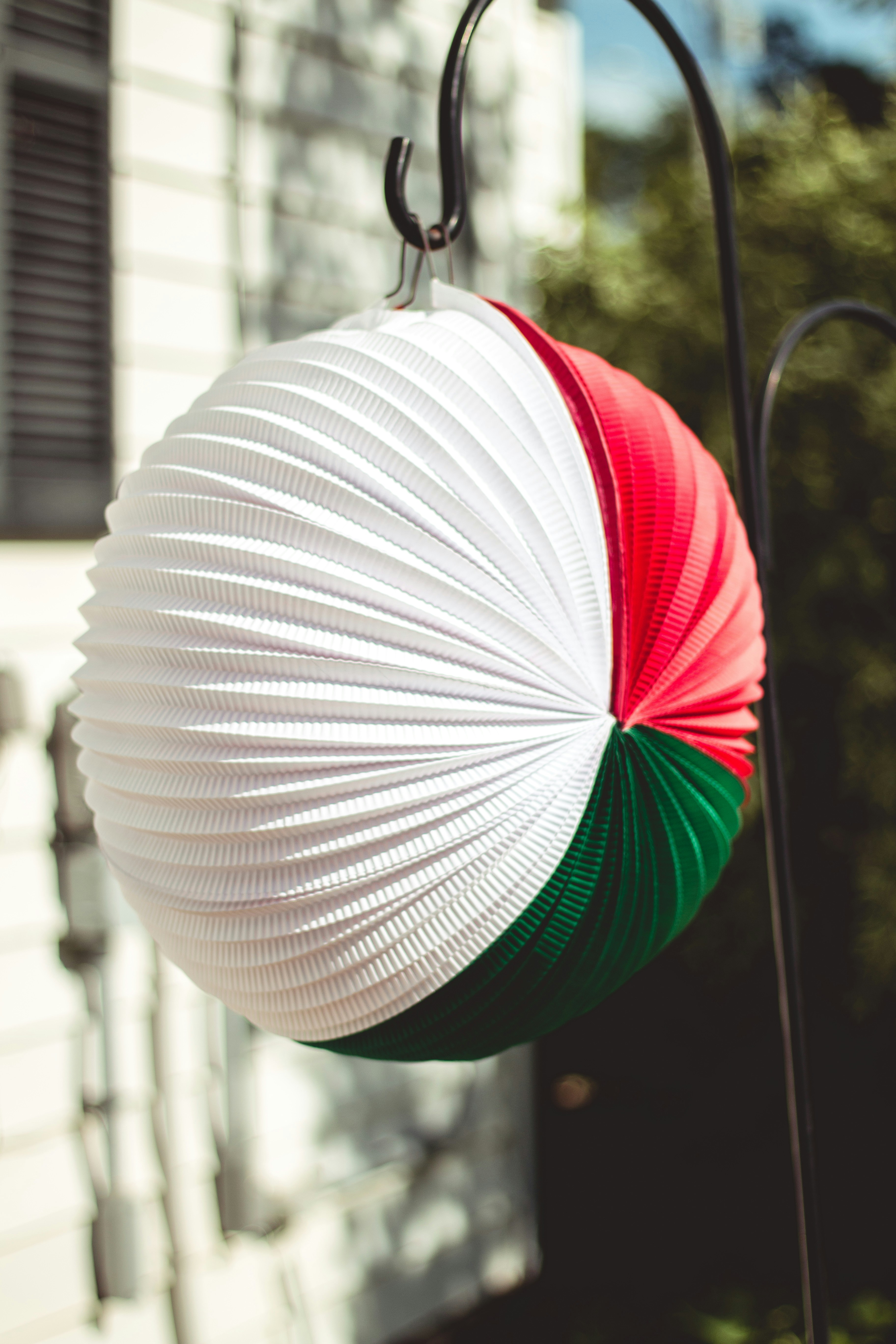A paper lantern with the Malagasy flag colors of white, which stands for purity, red for sovereignty and green for representing the coastal regions and symbolizes hope.