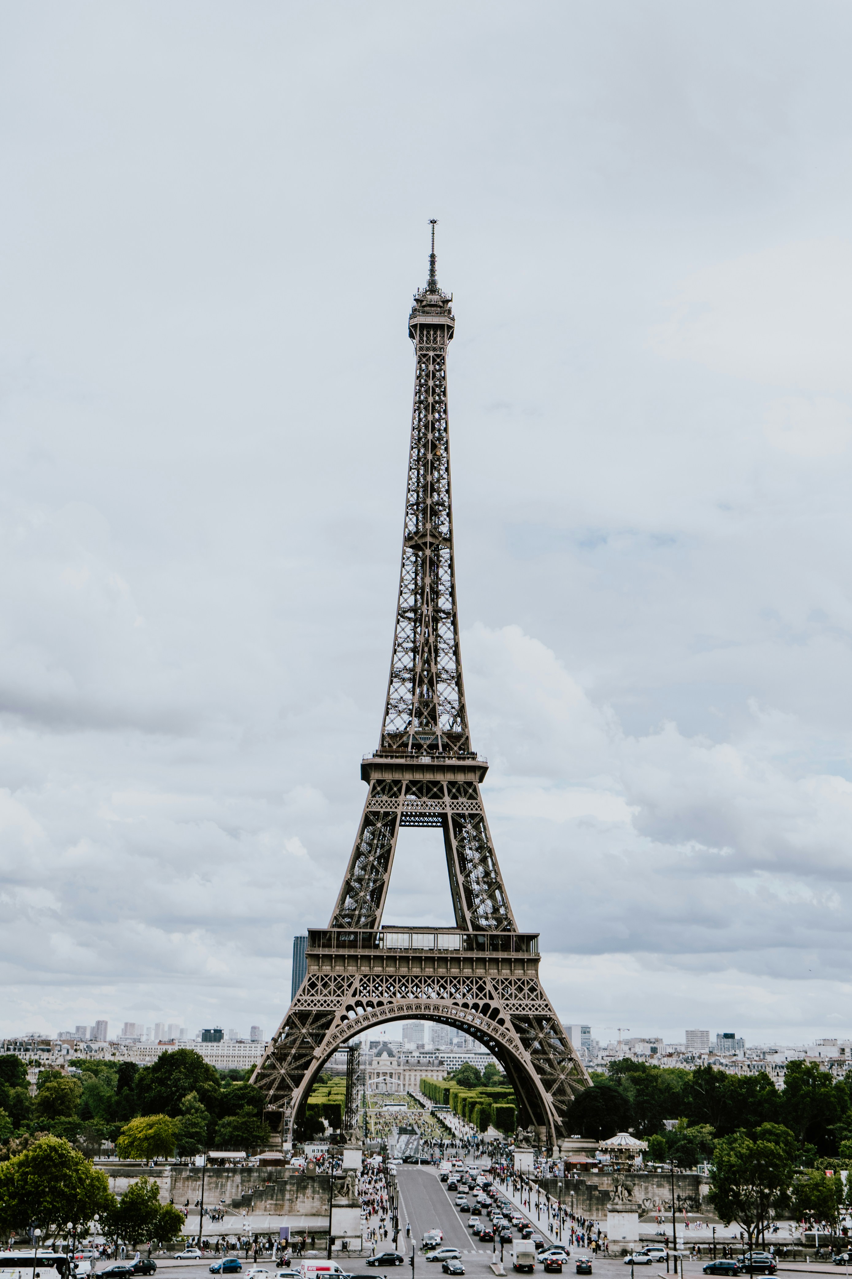 Eiffel Tower rising majestically against a cloudy sky, showcasing its intricate iron lattice design and the bustling city below.