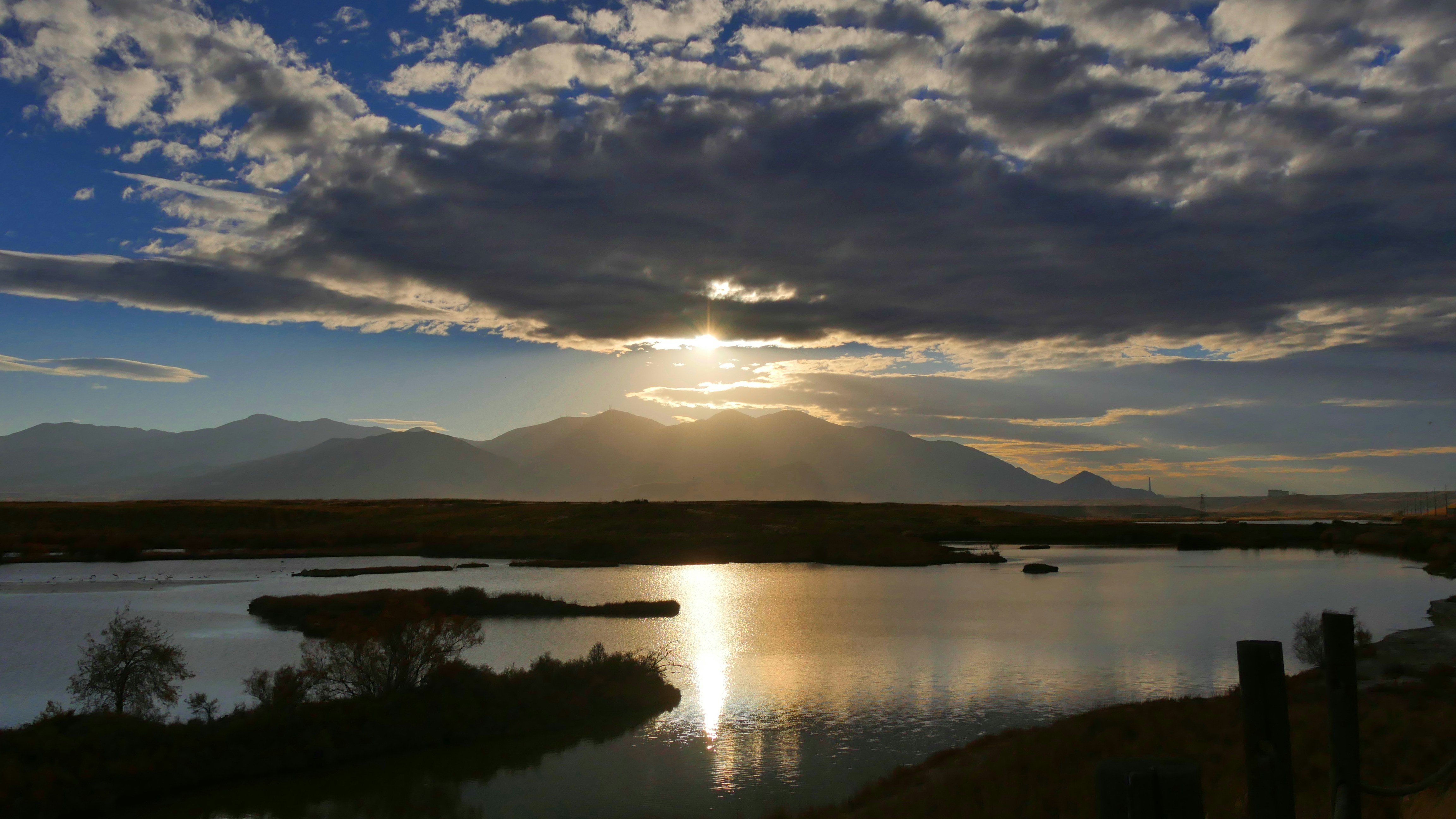 Mountain sunburst over water