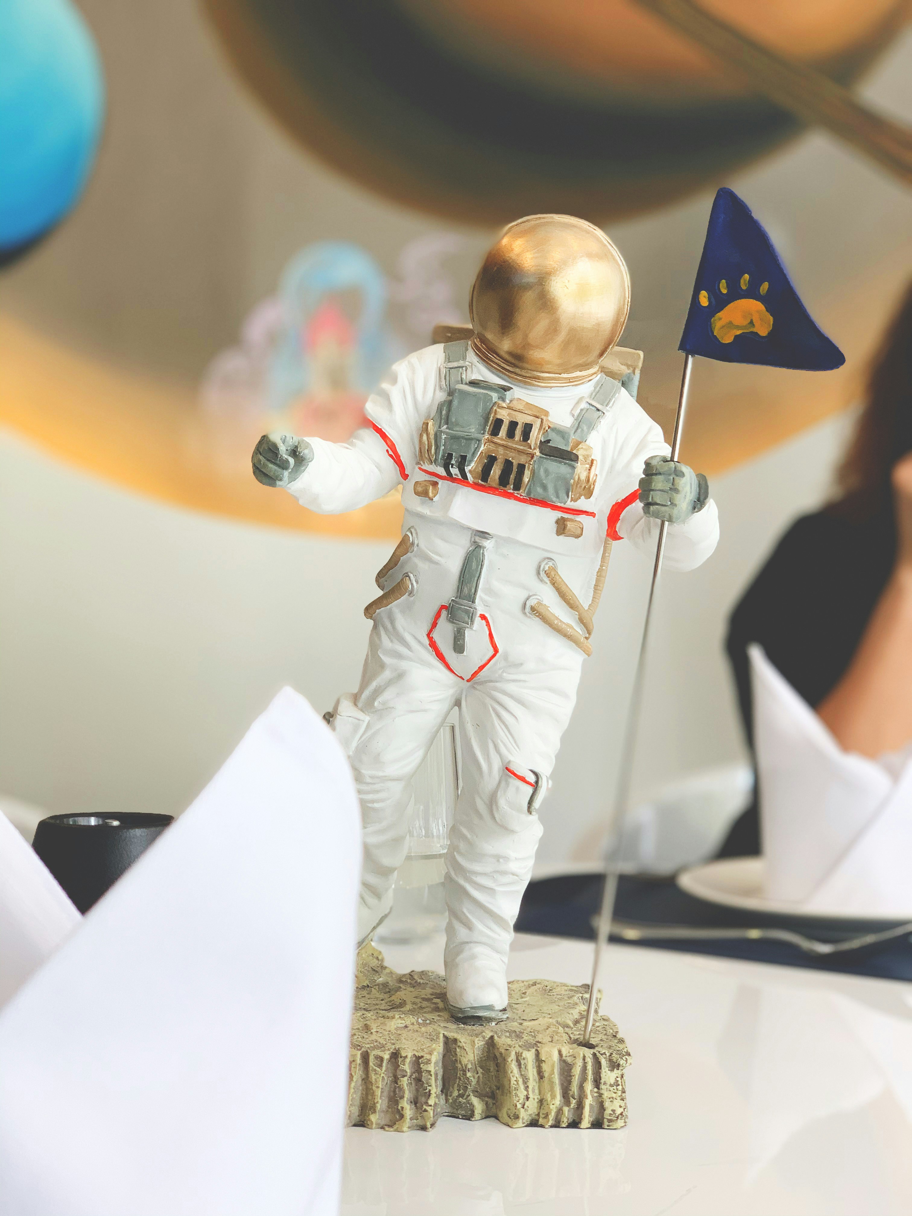 Astronaut Figurine on a Lunar Pedestal Under Soft Studio Light