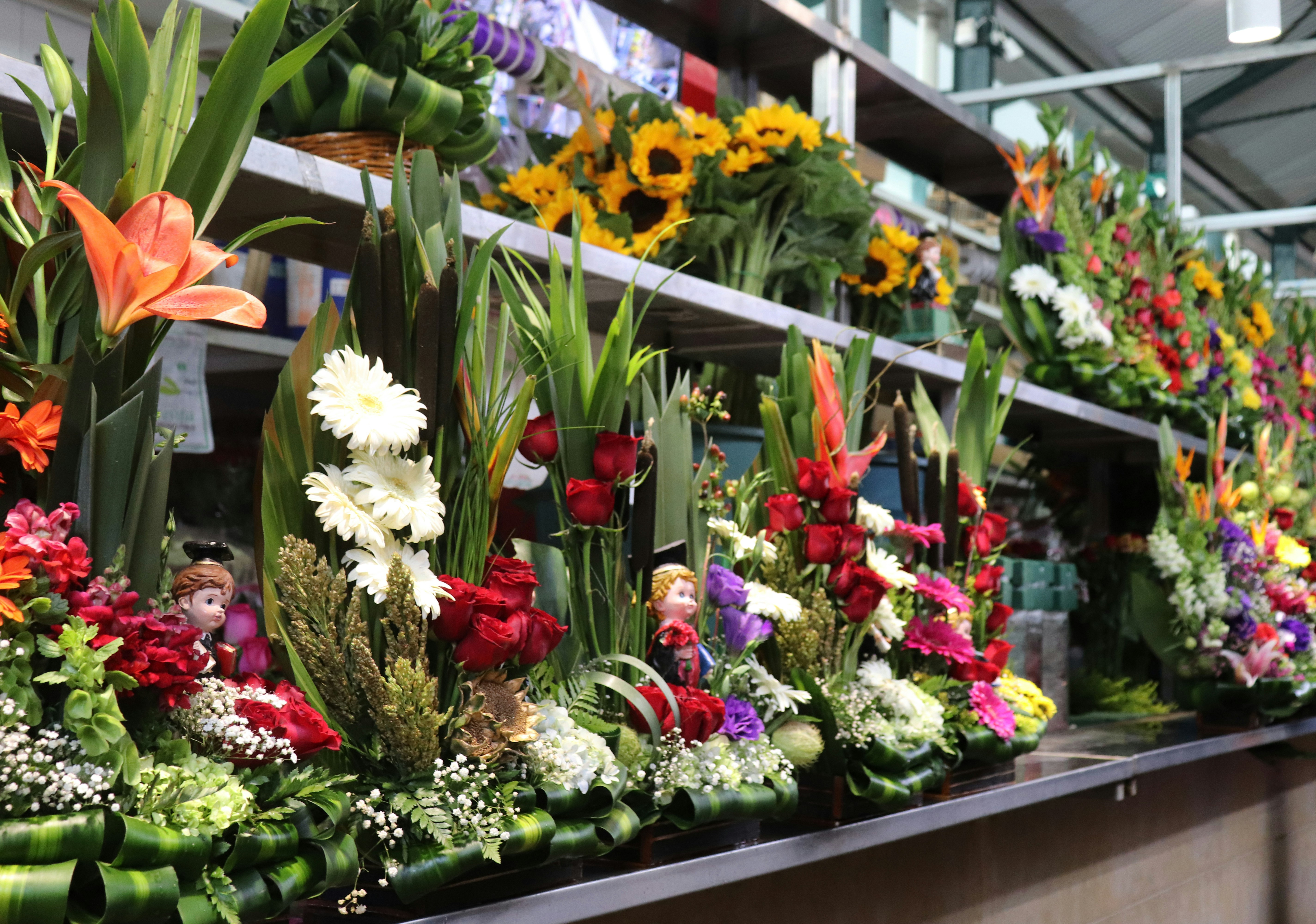 Aisle of Living Color: Sunflowers, Lilies, and Tiny Figurines in Bloom