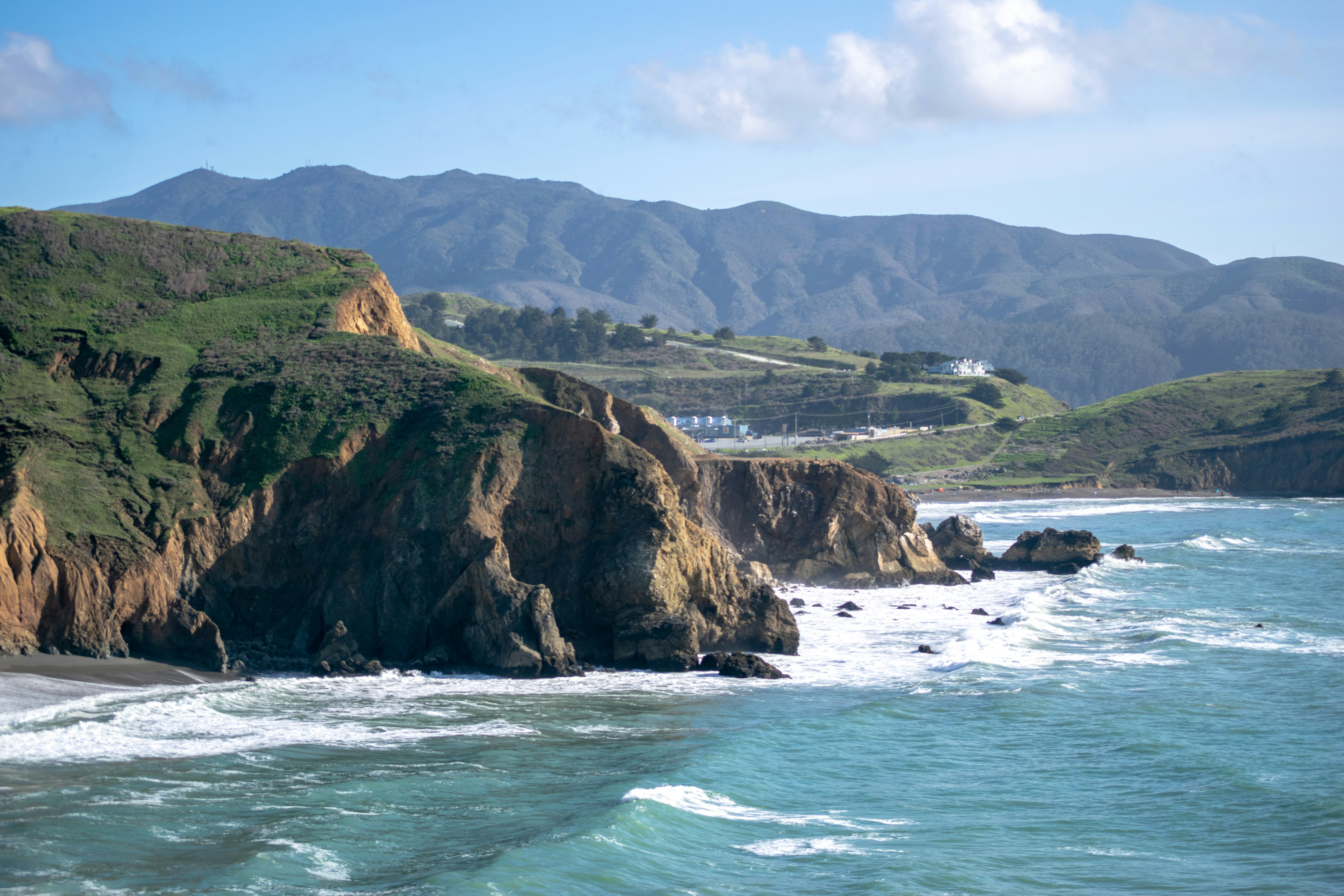 Sea beside mountain range under clear blue sky photo – Free Promontory ...