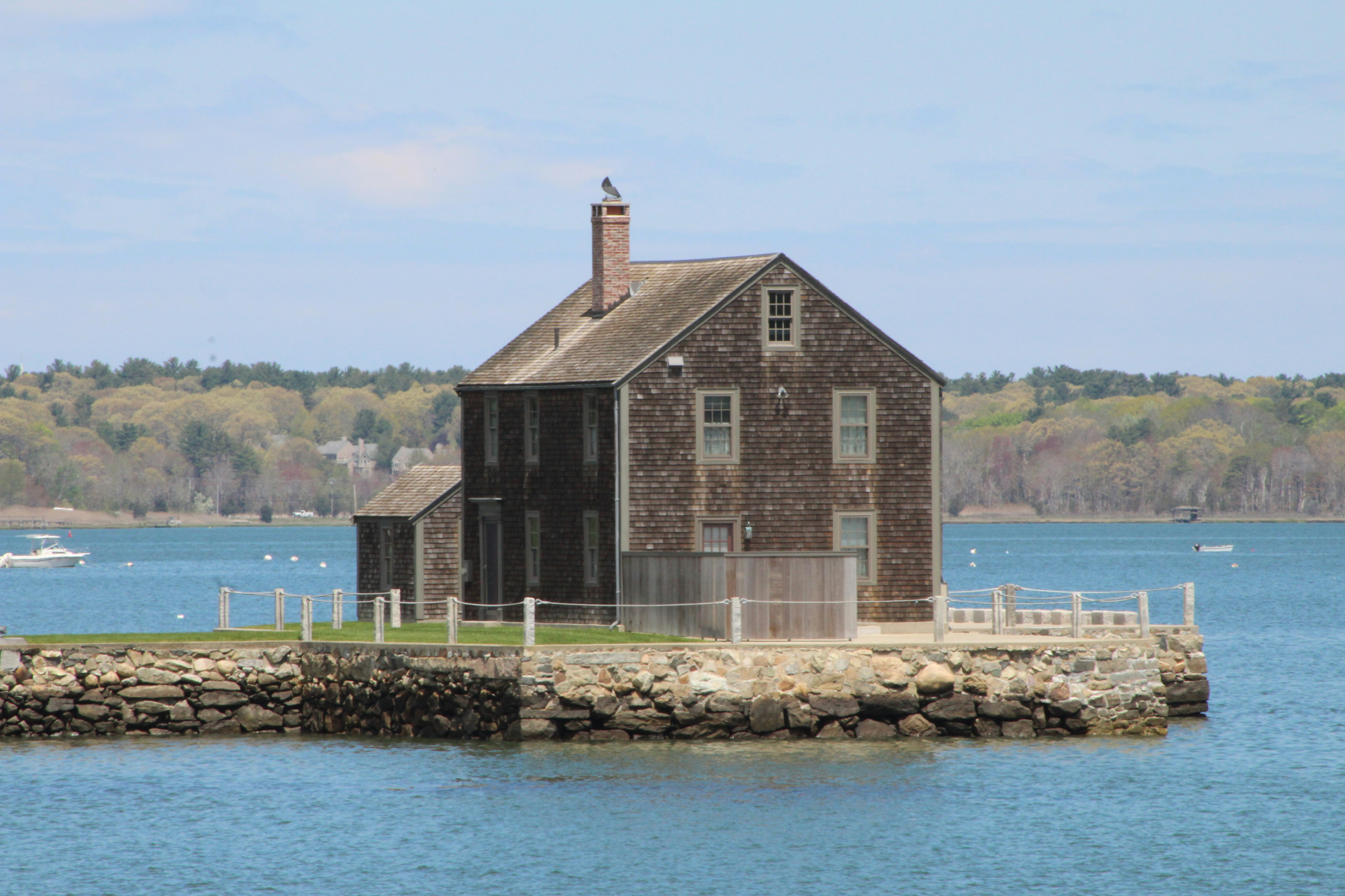 Lone mill-house on a stone jetty amid calm blue waters