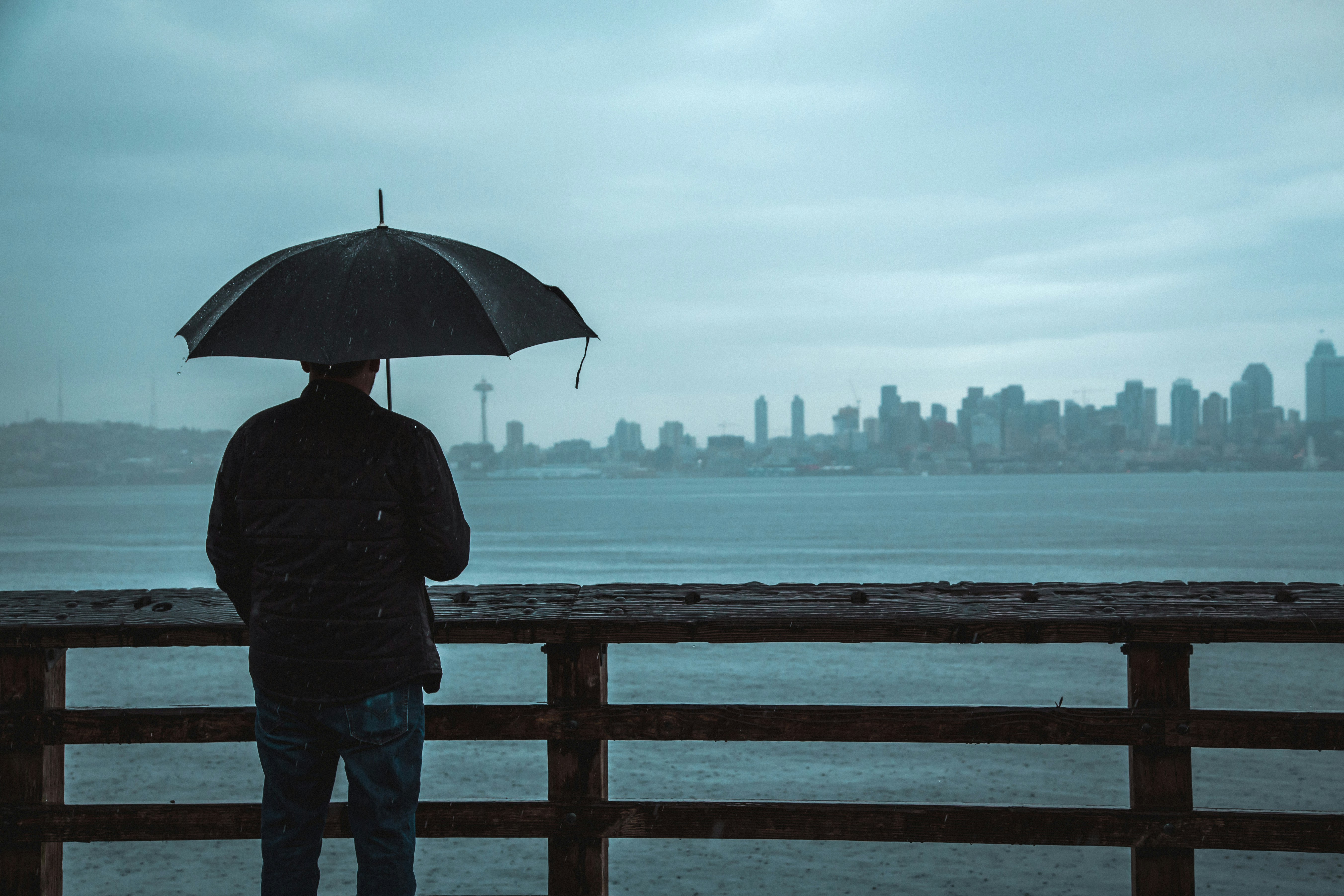 Man using umbrella standing on wooden dock photo – Free Human Image on ...