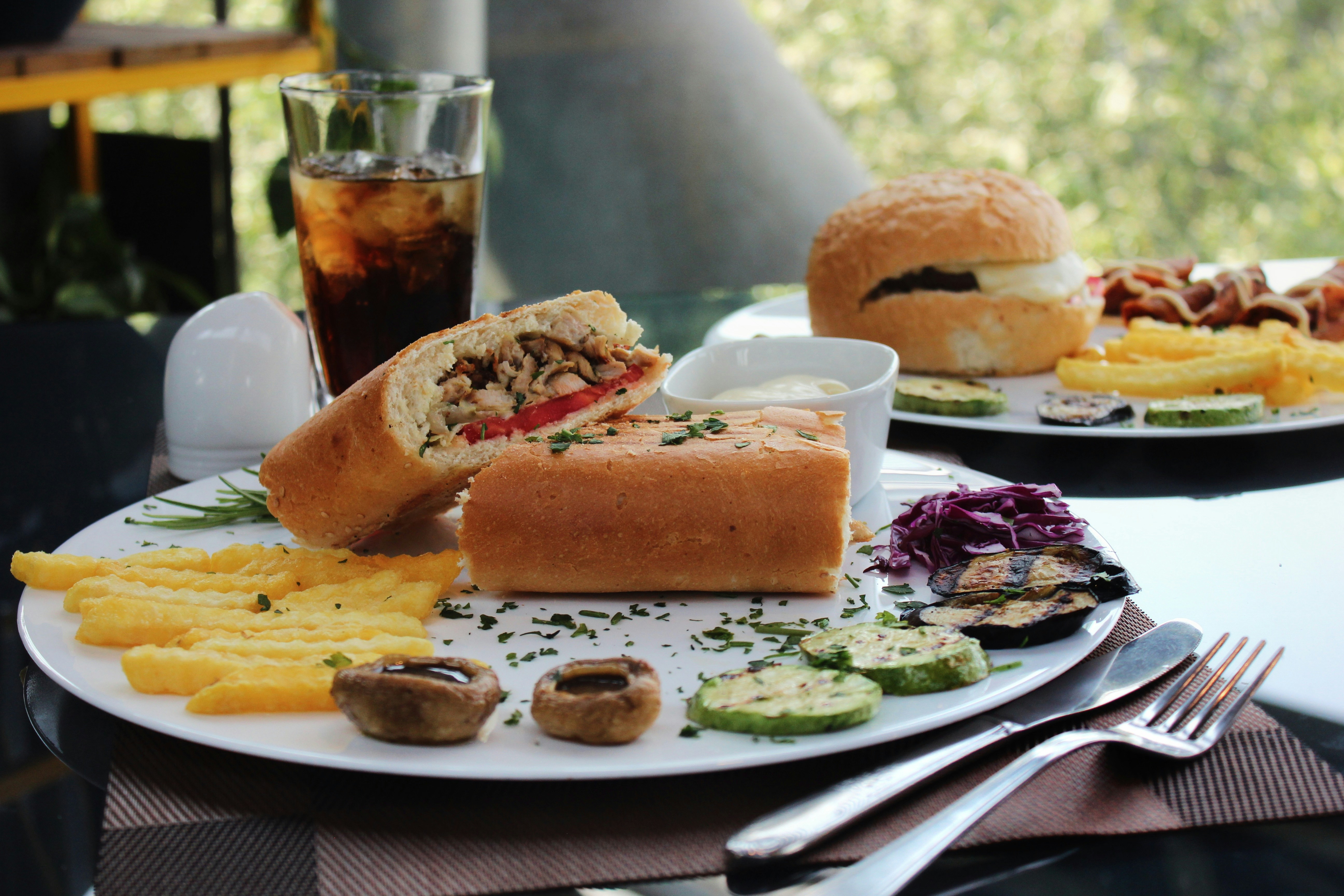 Sunlit Café Platter: Open-Faced Sandwich, Fries, and Fresh Veggies on a Rustic Table