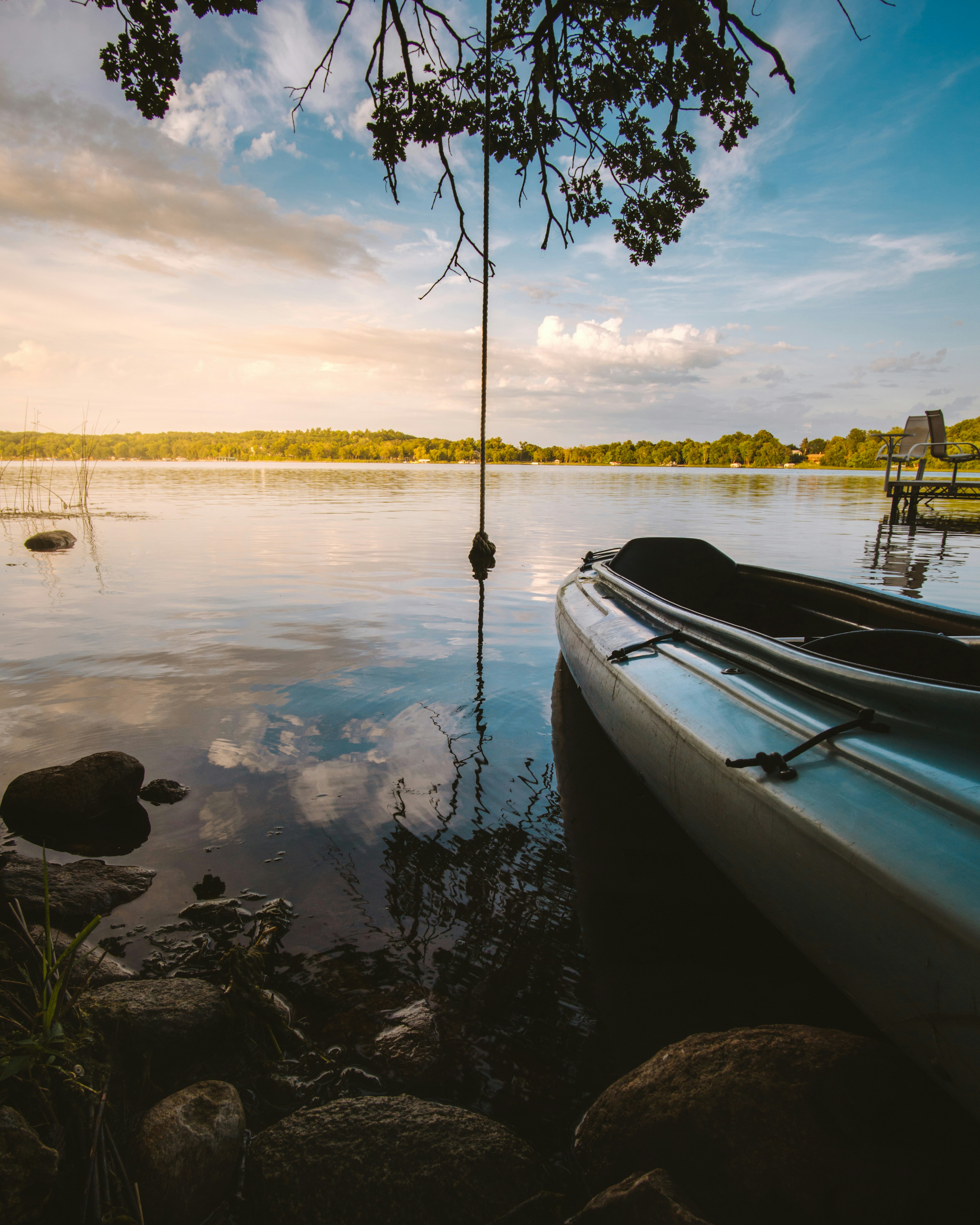 Reflections at the Edge: A Boat Resting by a Glassy Lake at Sunset