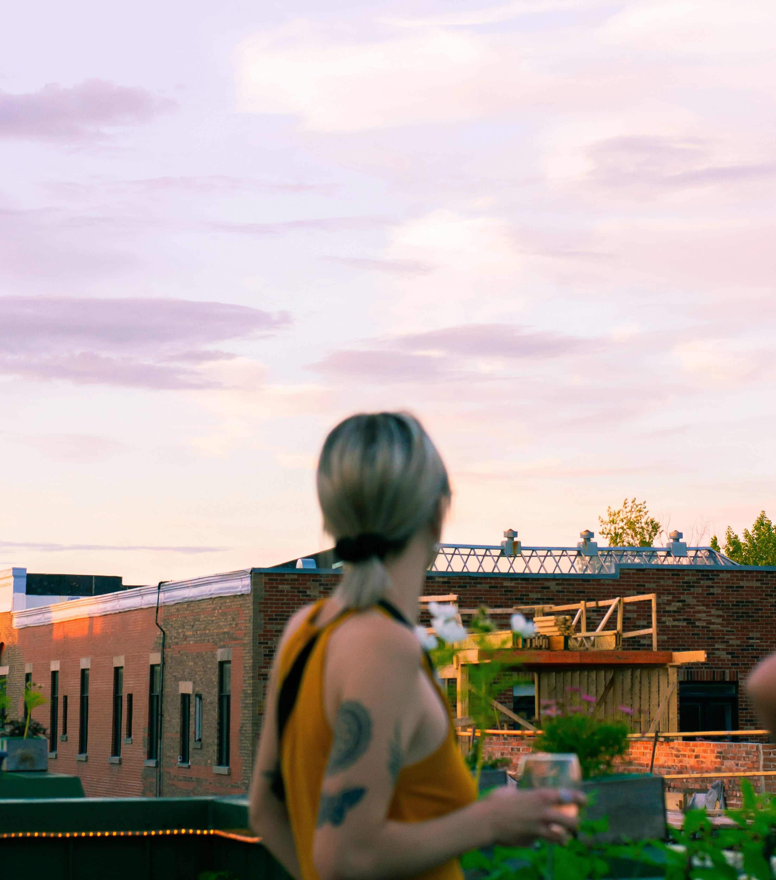 Rooftop Pause at Dusk: A Blurred Figure Amid Pastel Skies