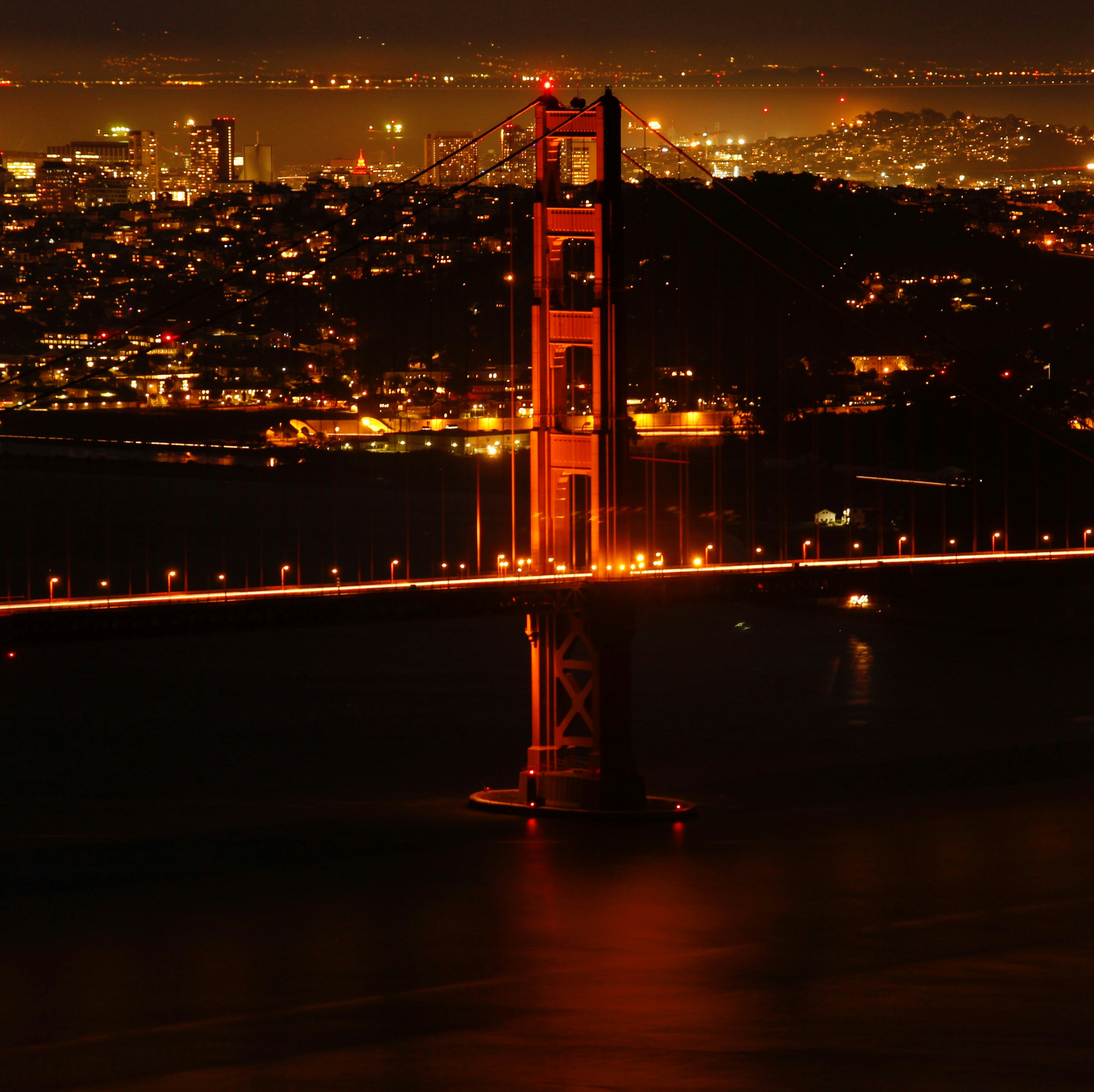 Glowing Span: The Golden Gate at Night Across Quiet Waters