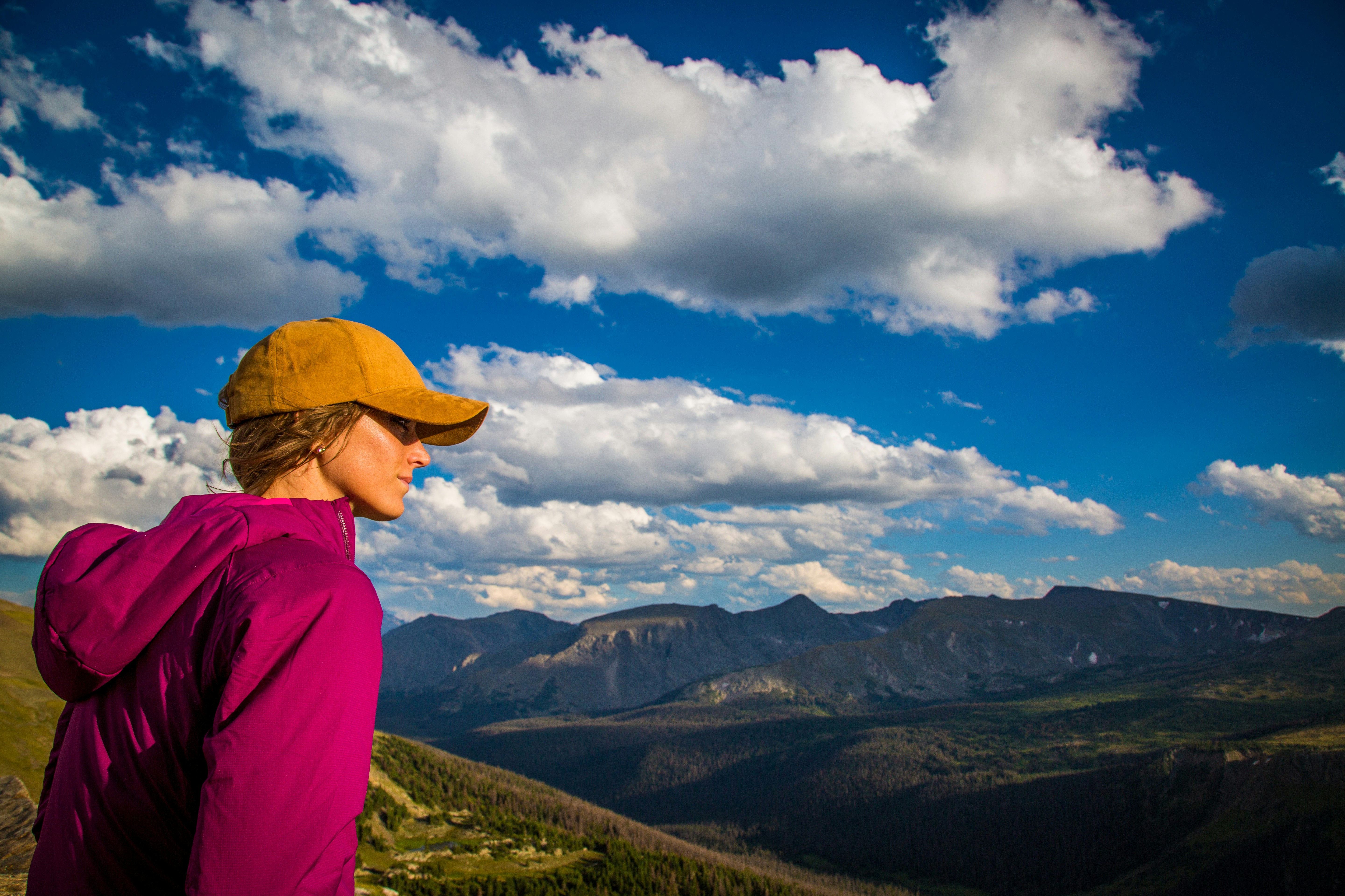 Magenta on the Ridge: A Hiker Pauses Over a Rugged Mountain Vista
