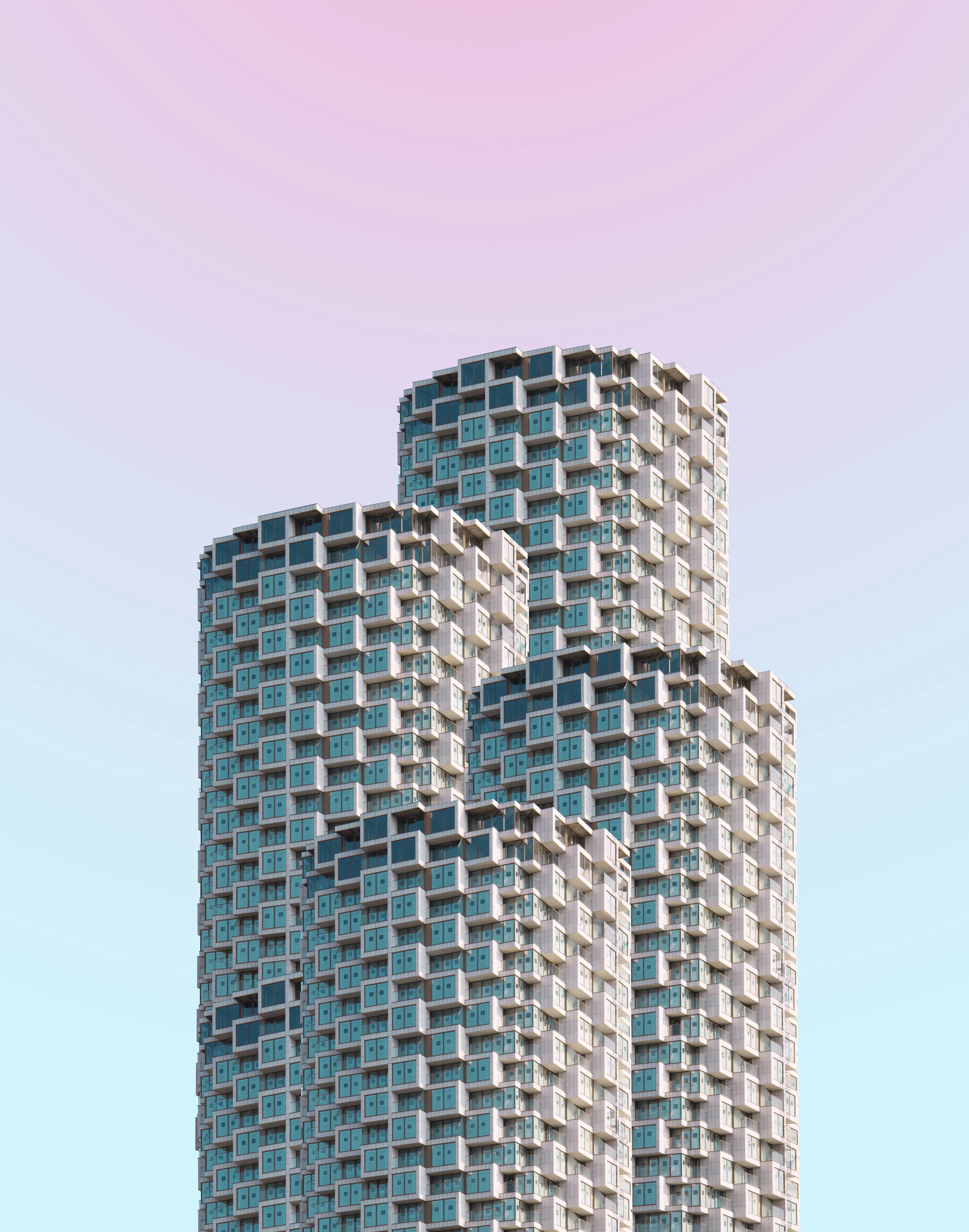 A cluster of uniquely designed high-rise buildings showcasing intricate geometric patterns against a gradient sky.