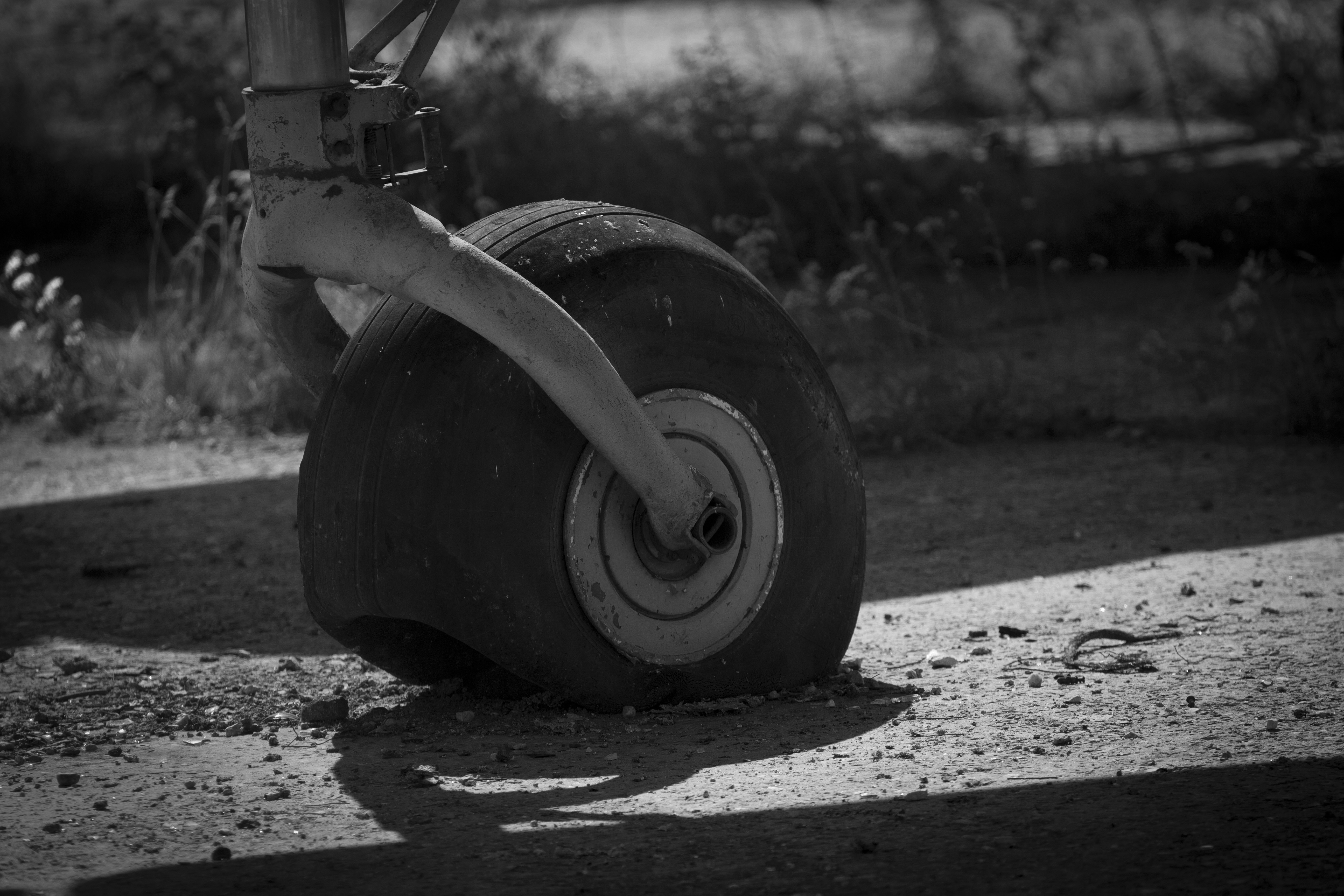 Monochrome Wheel: Quiet Industrial Moment on Rough Concrete
