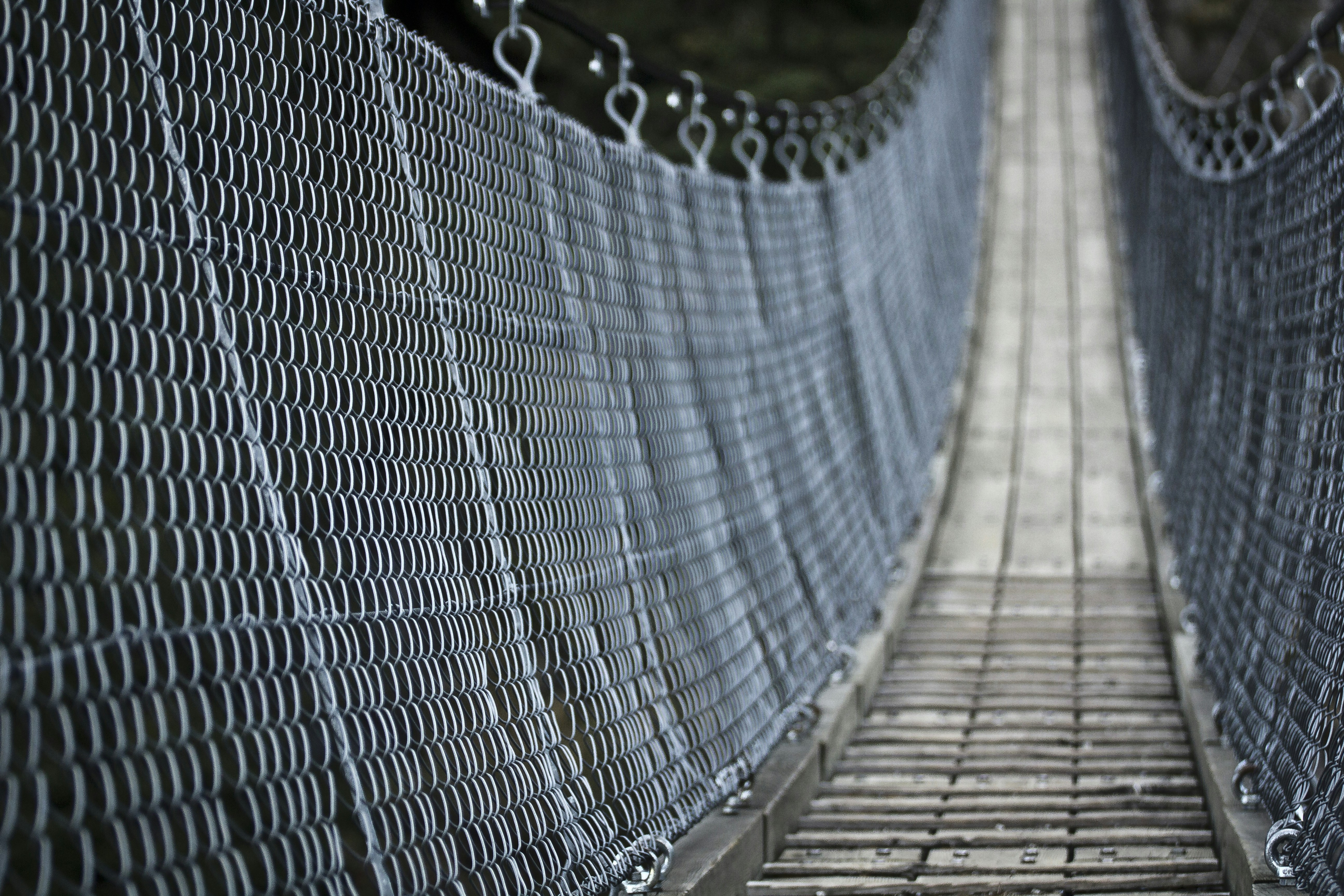Vanishing Point on a Chain-Link Bridge Walkway