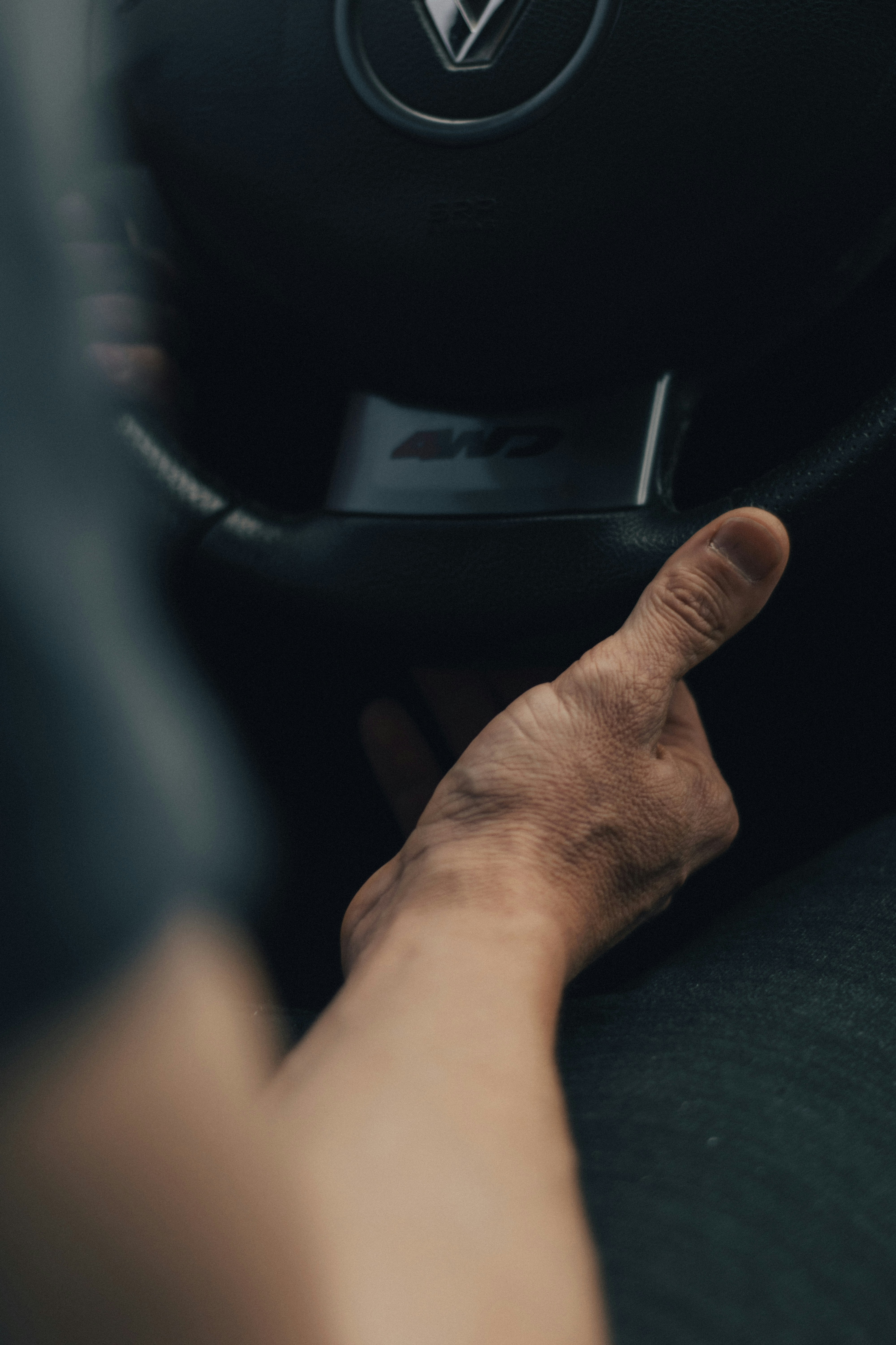 Close-up of a hand gripping a steering wheel, symbolizing focus and direction while driving.