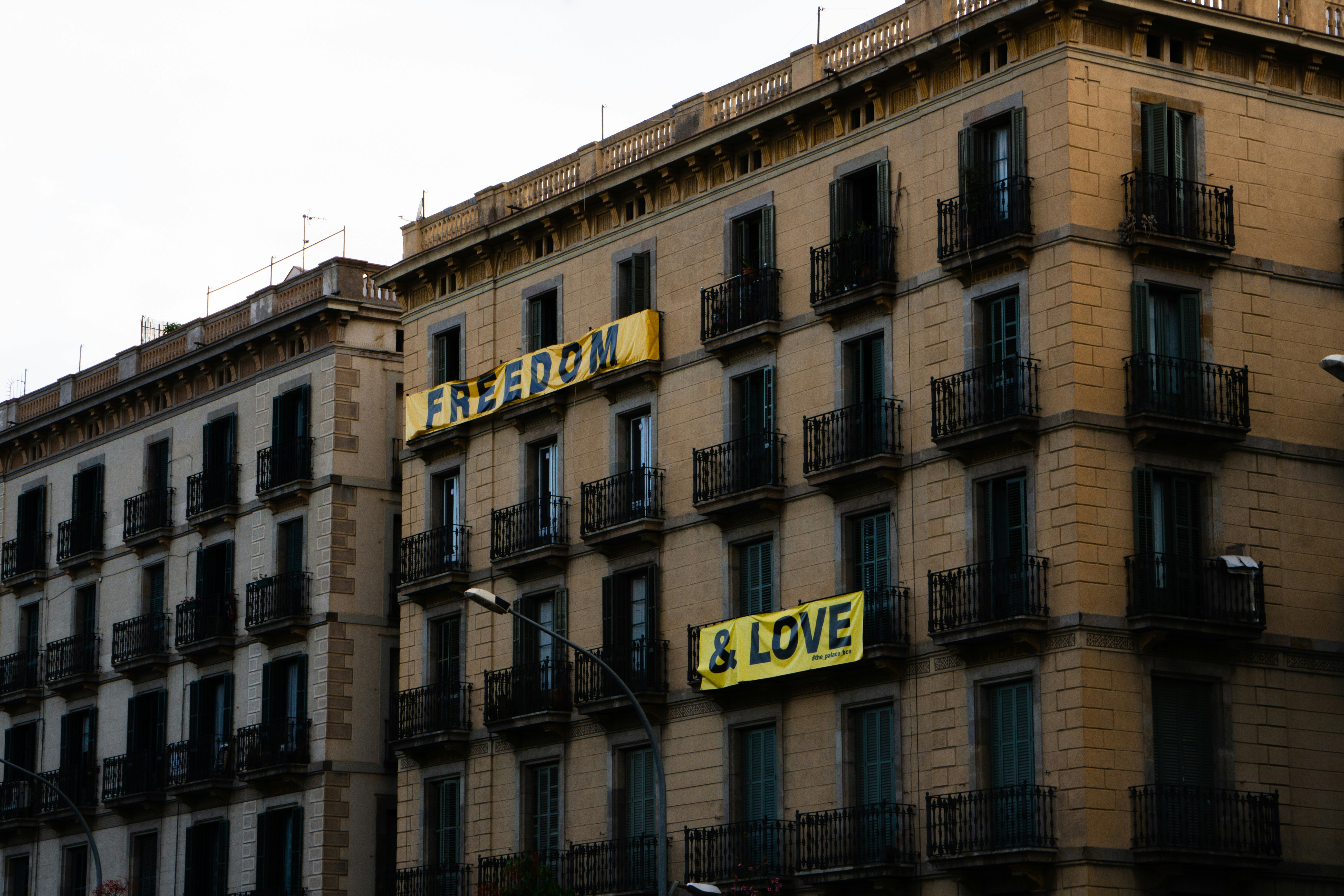 Building facade adorned with large banners reading 'FREEDOM' and '& LOVE', emphasizing a message of unity and hope.